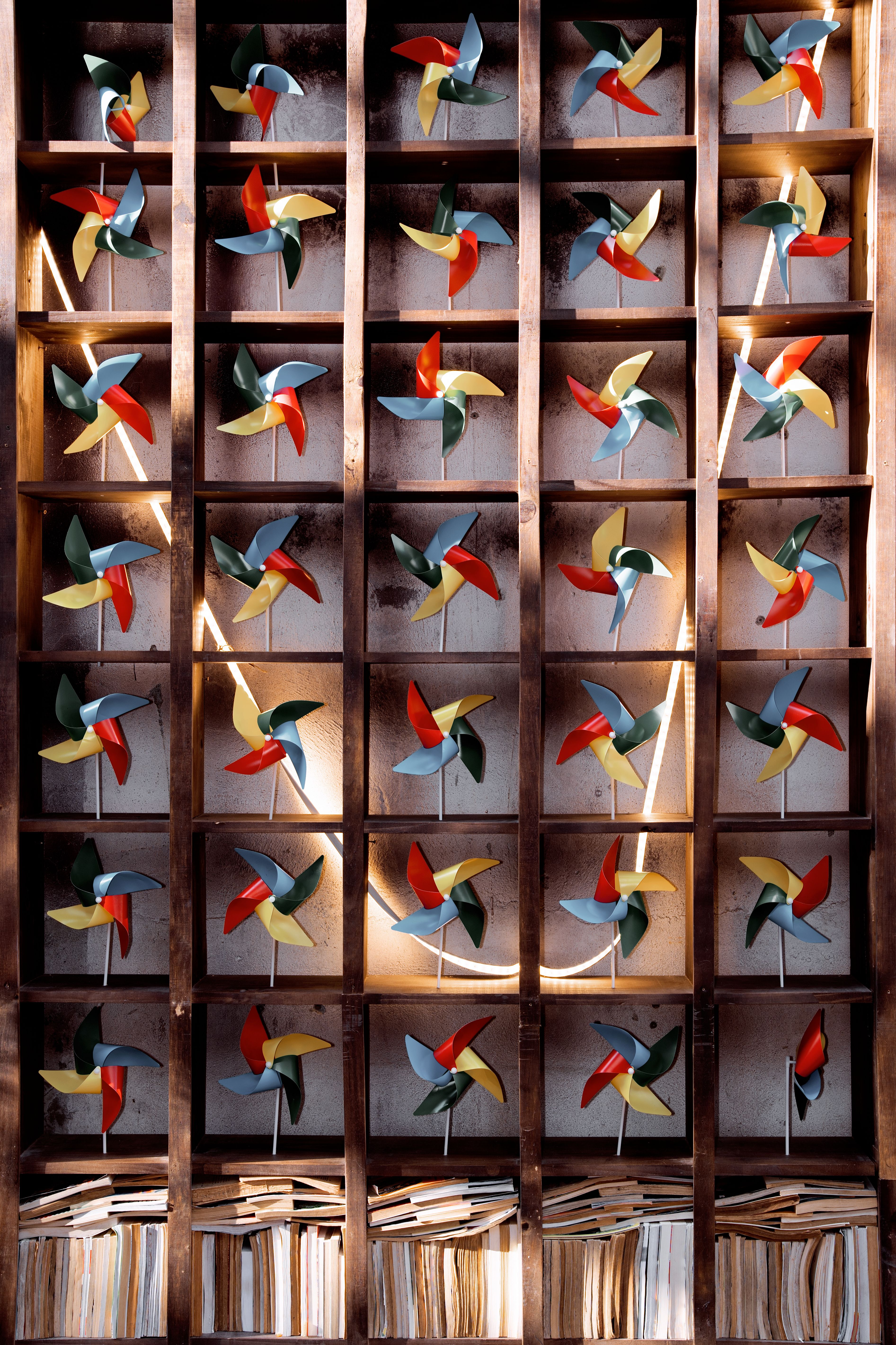 Colorful Pinwheels in Wooden Grid Display · Free Stock Photo