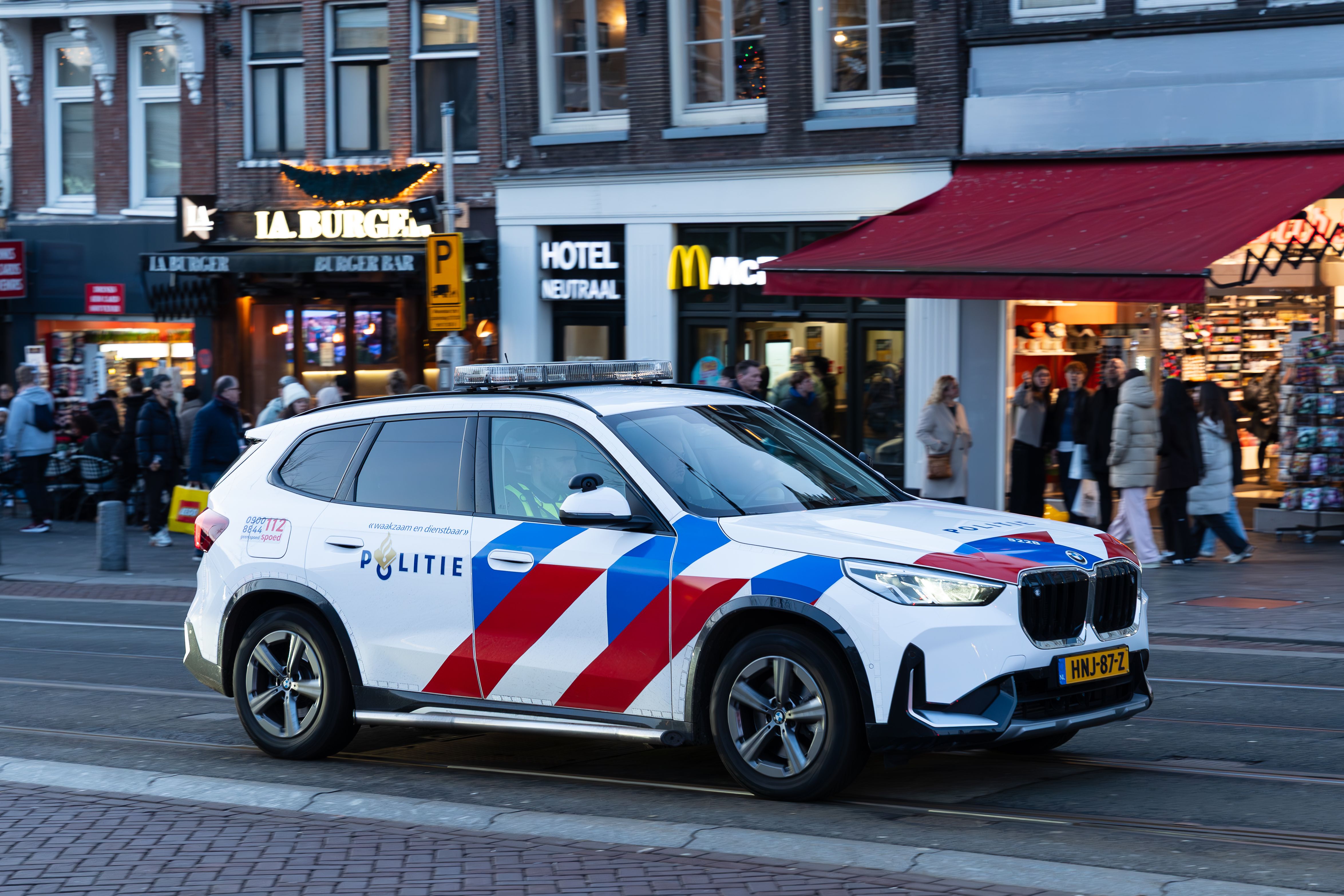 Dutch Police Car in Lively Amsterdam Street · Free Stock Photo