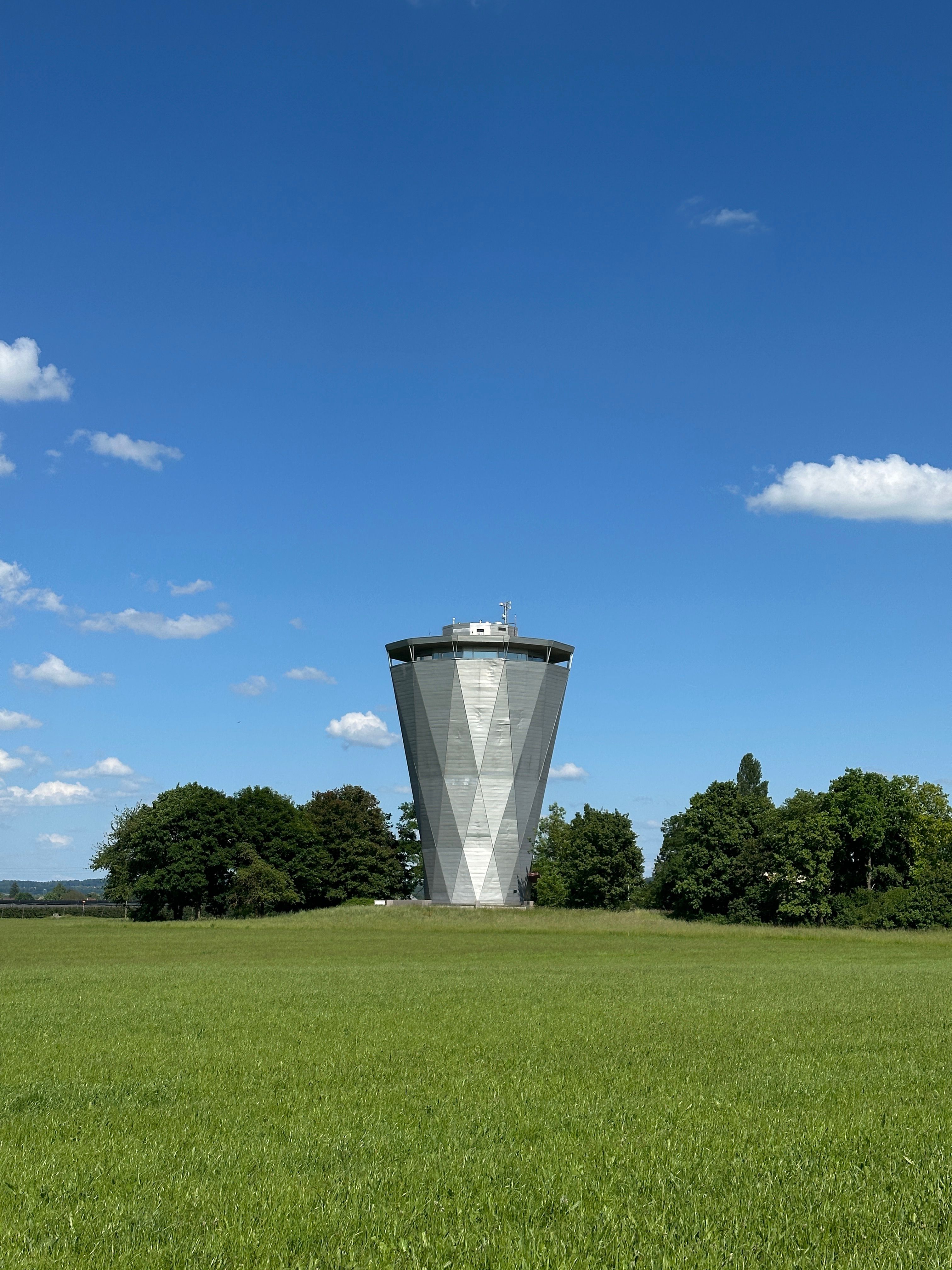 Modern Water Tower in Green Field Under Blue Sky · Free Stock Photo