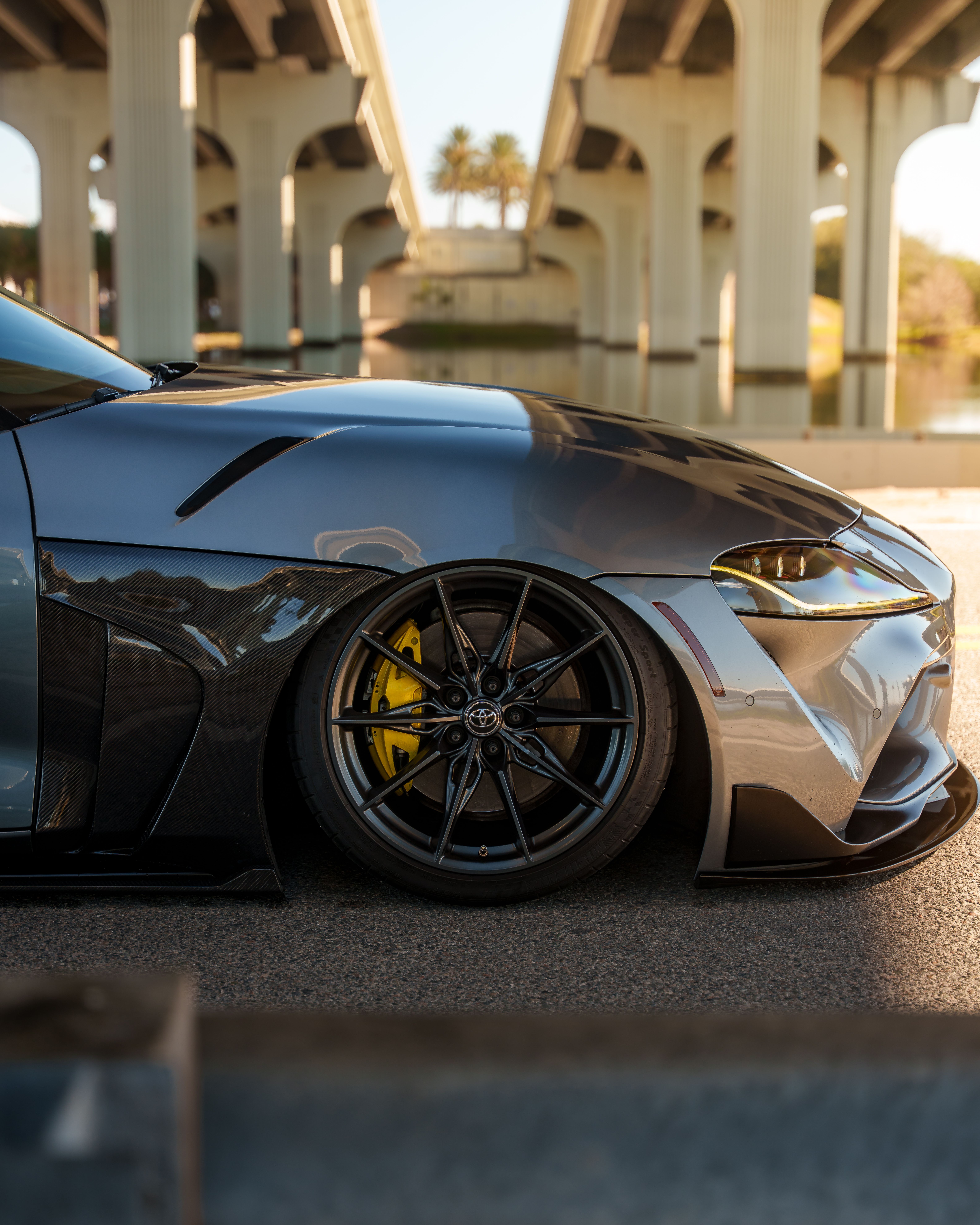 Sleek Sports Car Under Urban Bridge in Daylight · Free Stock Photo