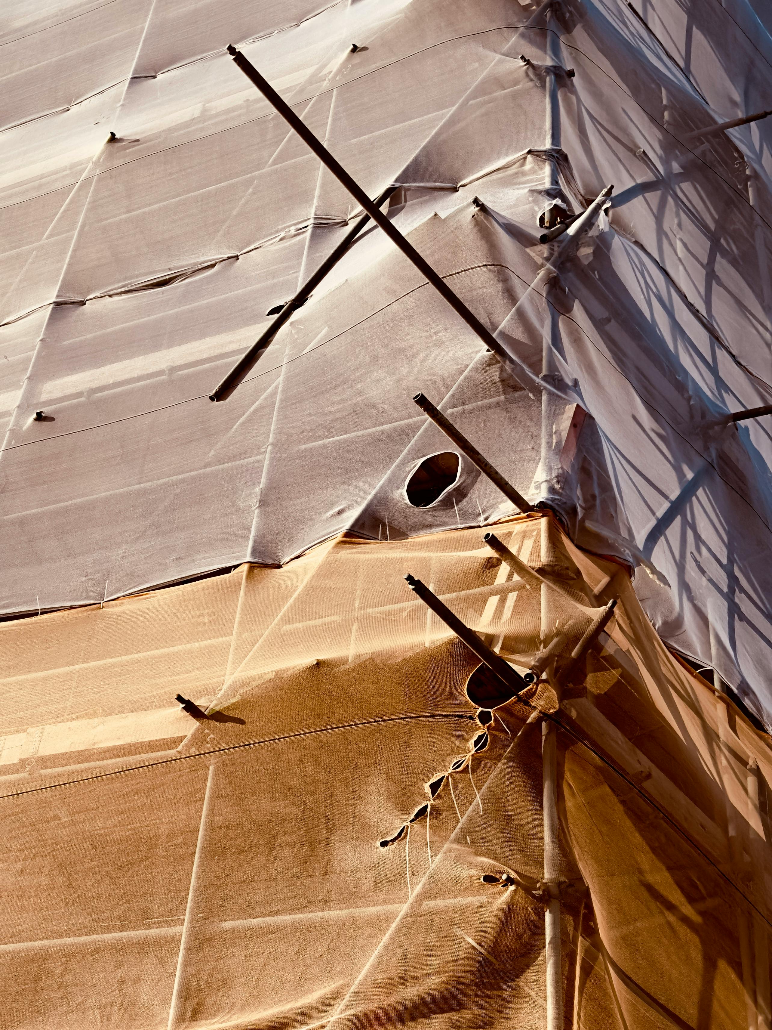 Scaffolding structure covered with protective tarp · Free Stock Photo
