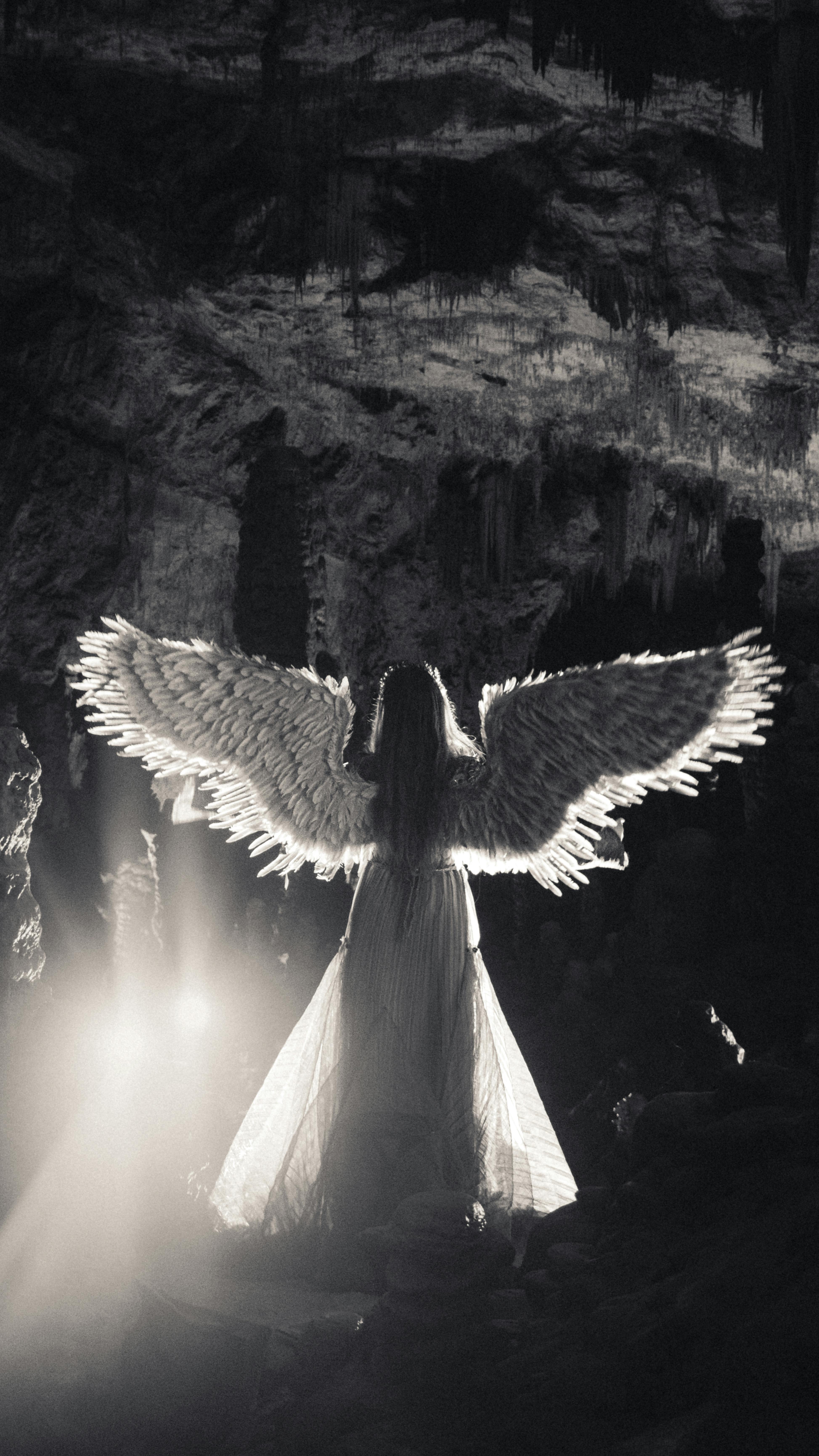 Ethereal Angel Figure in Dramatic Cave Lighting · Free Stock Photo