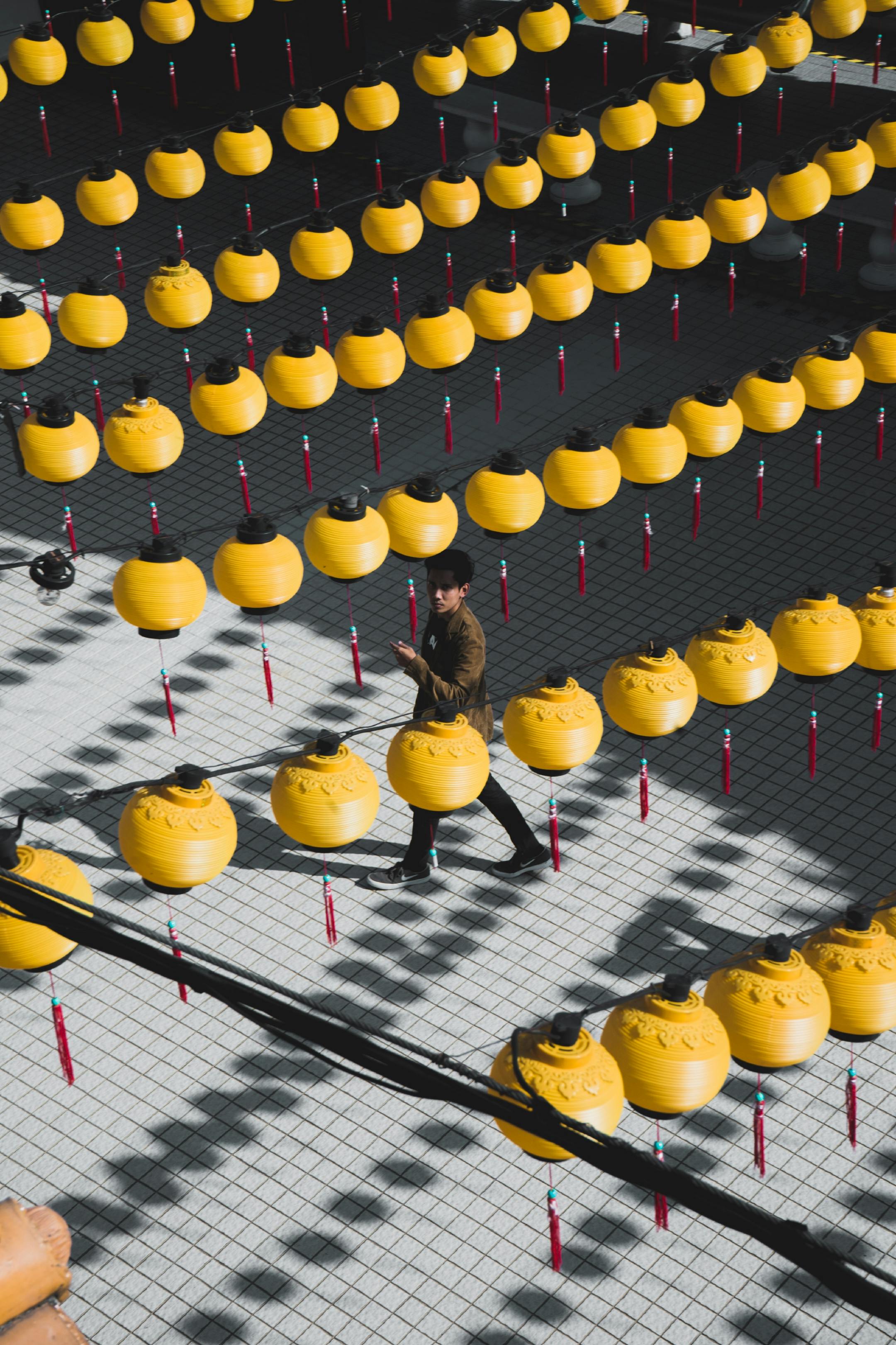 Man Walking Under Yellow String Lights · Free Stock Photo