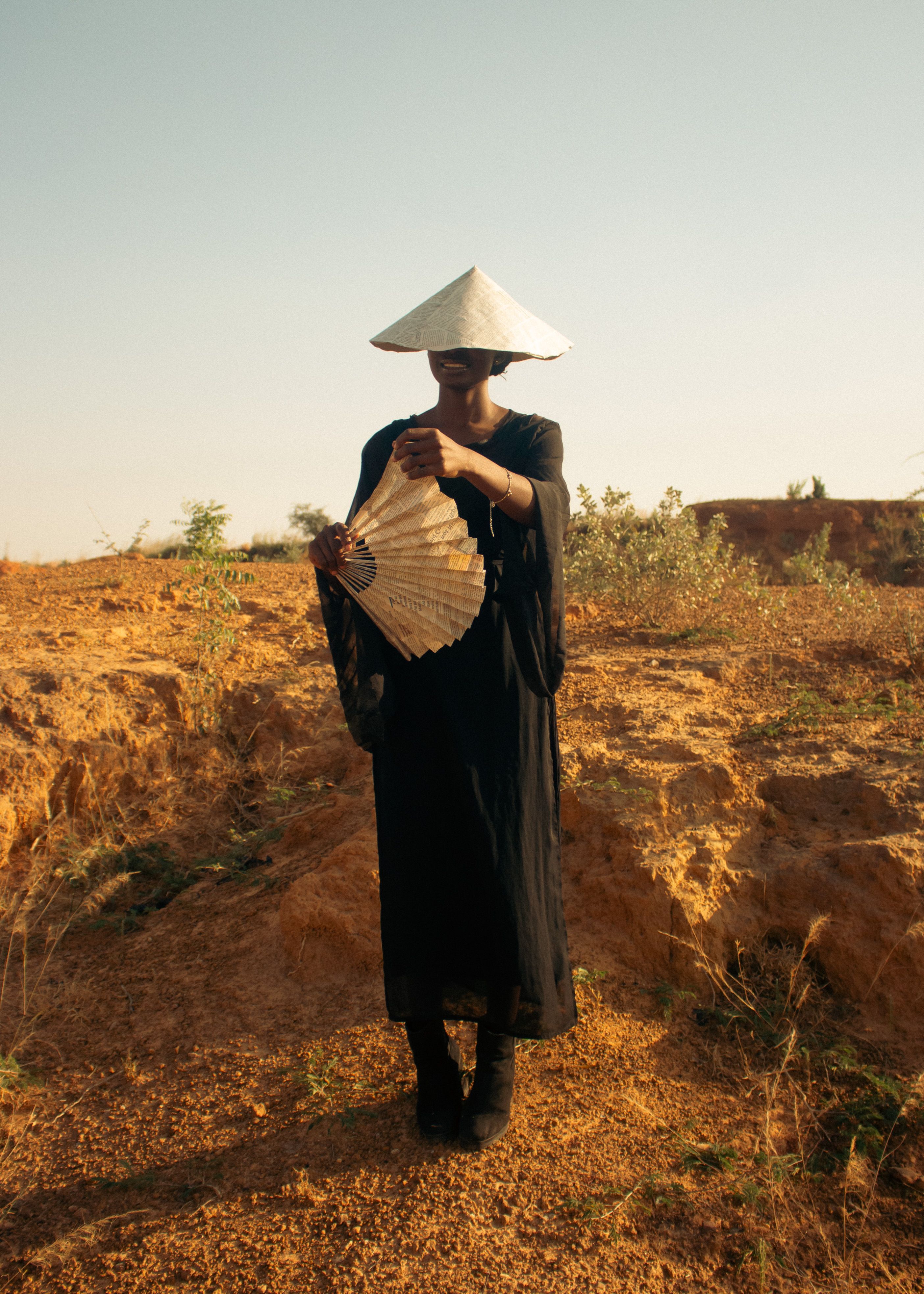 Person in Traditional Attire Holding a Hand Fan Outdoors · Free Stock Photo