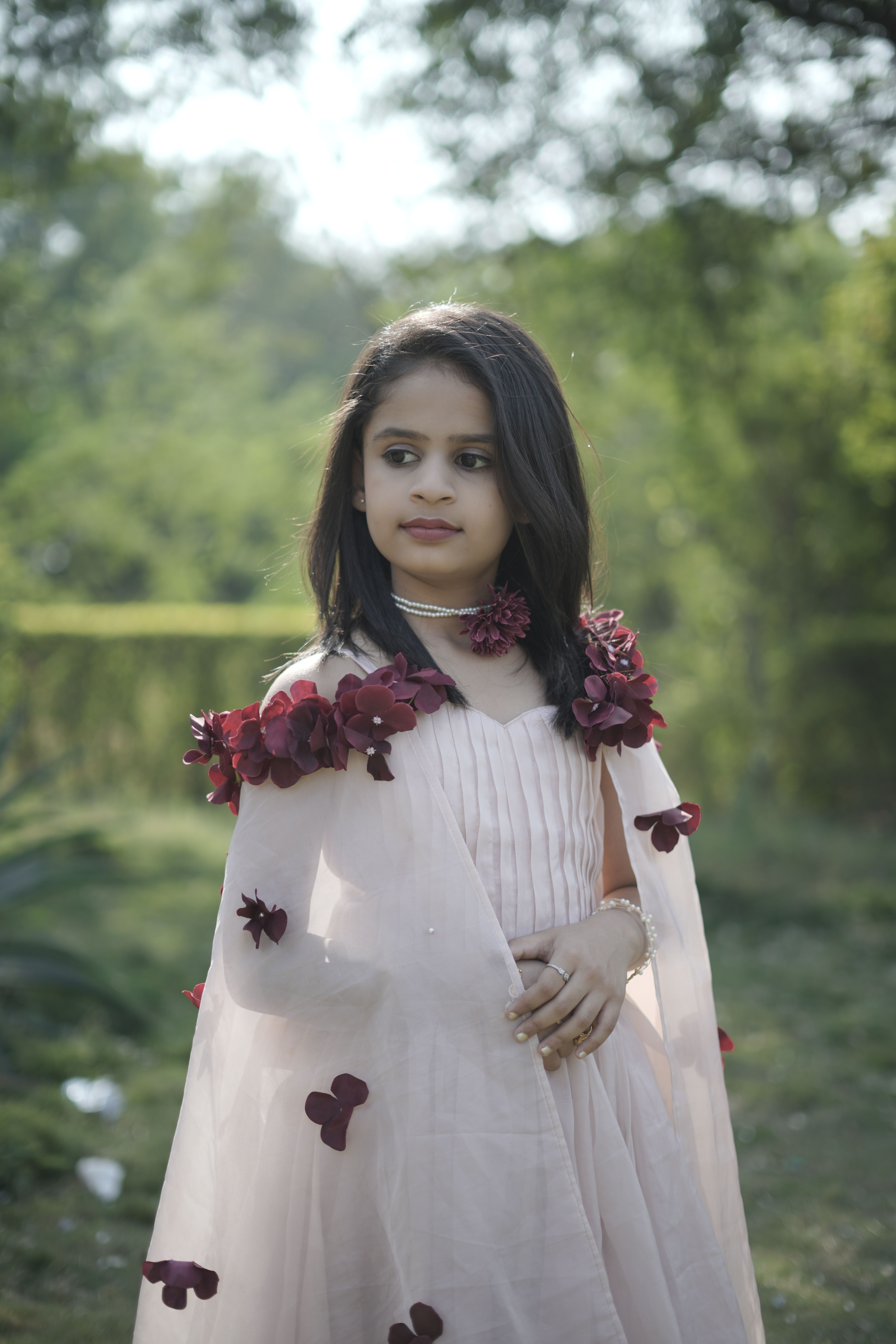 Young girl in floral dress in serene outdoor setting · Free Stock Photo