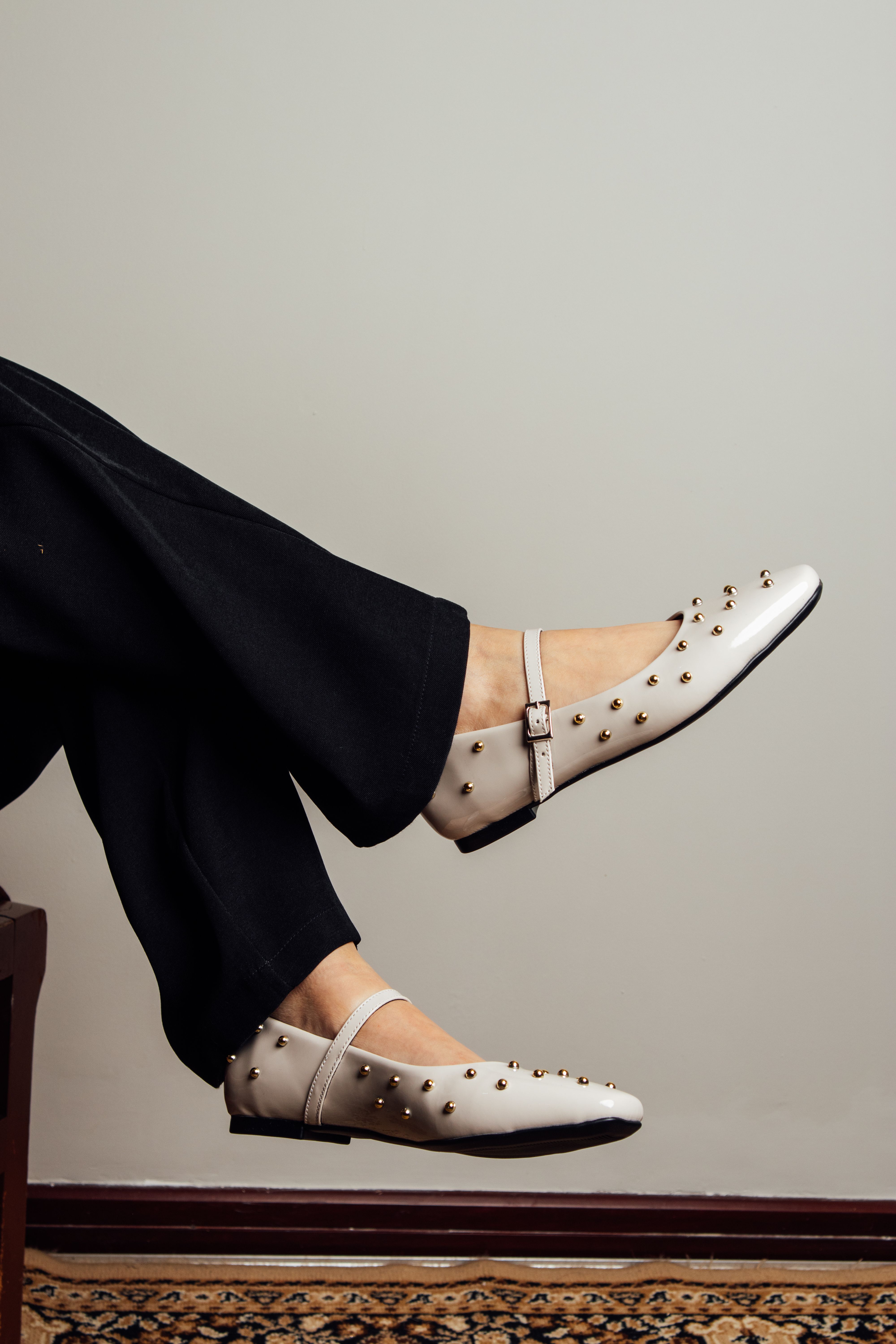 Elegant Studded Shoes on Relaxed Legs Indoors · Free Stock Photo
