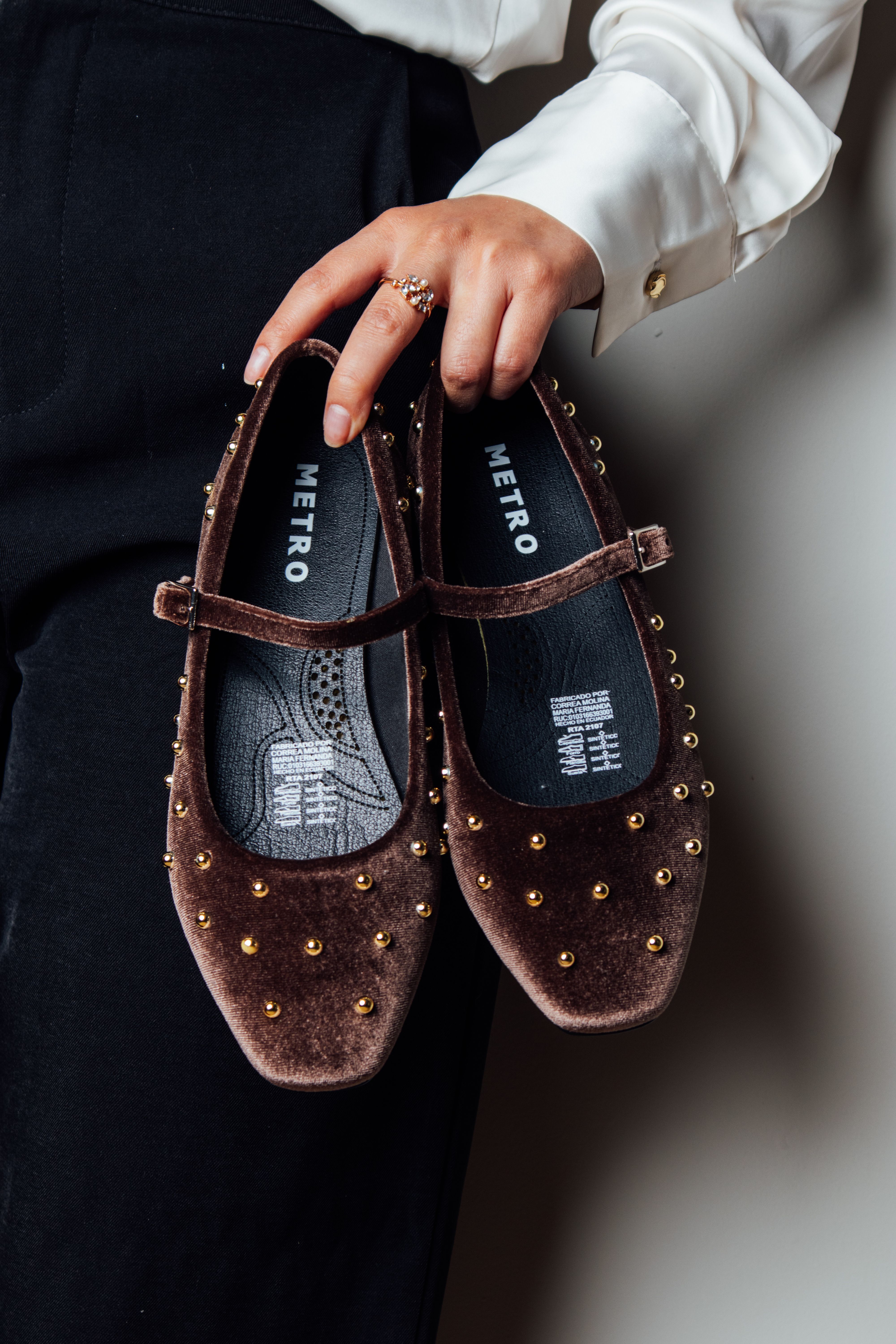 Elegant Velvet Shoes with Gold Studs in Hand · Free Stock Photo