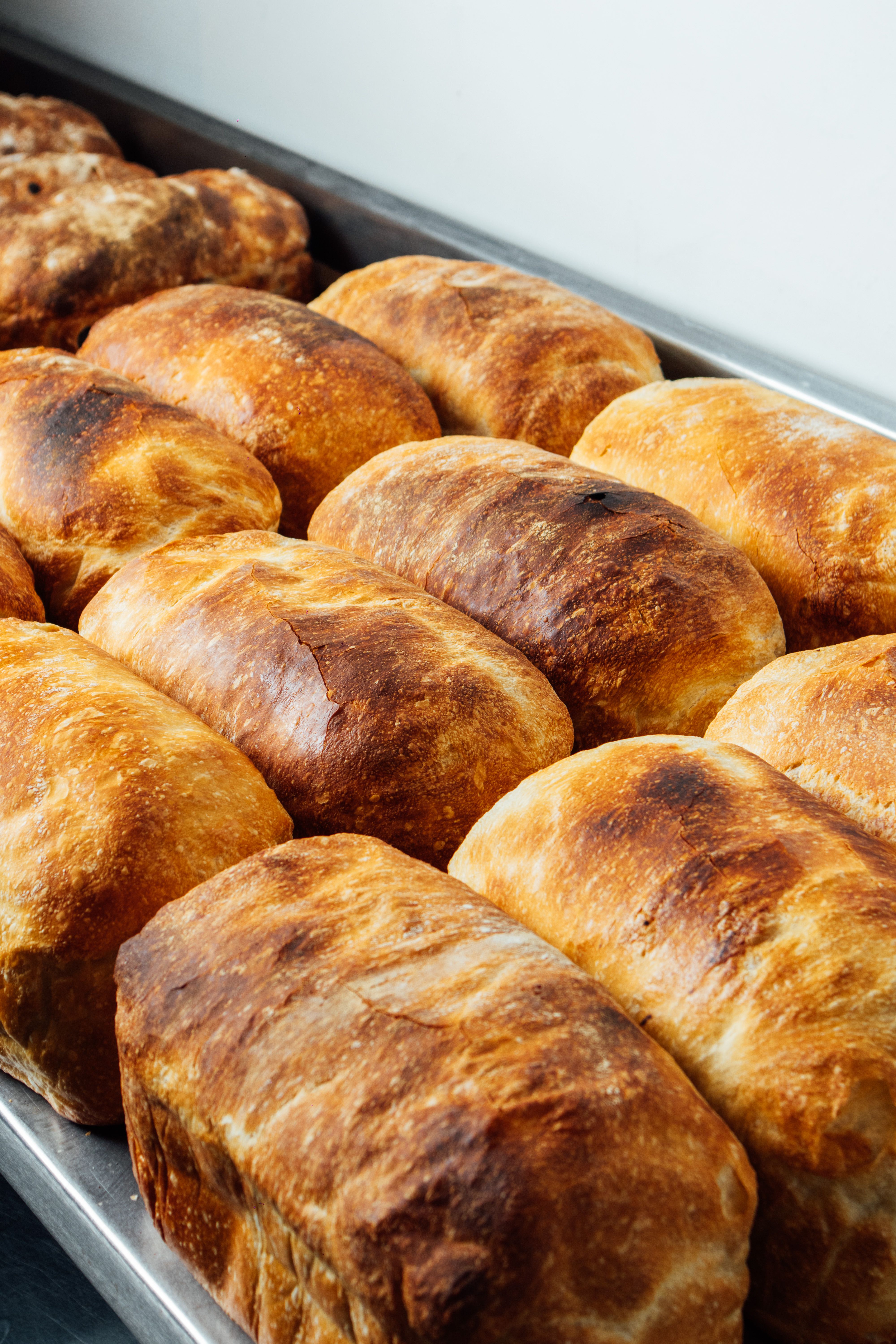 Freshly Baked Artisan Bread Loaves on Tray · Free Stock Photo