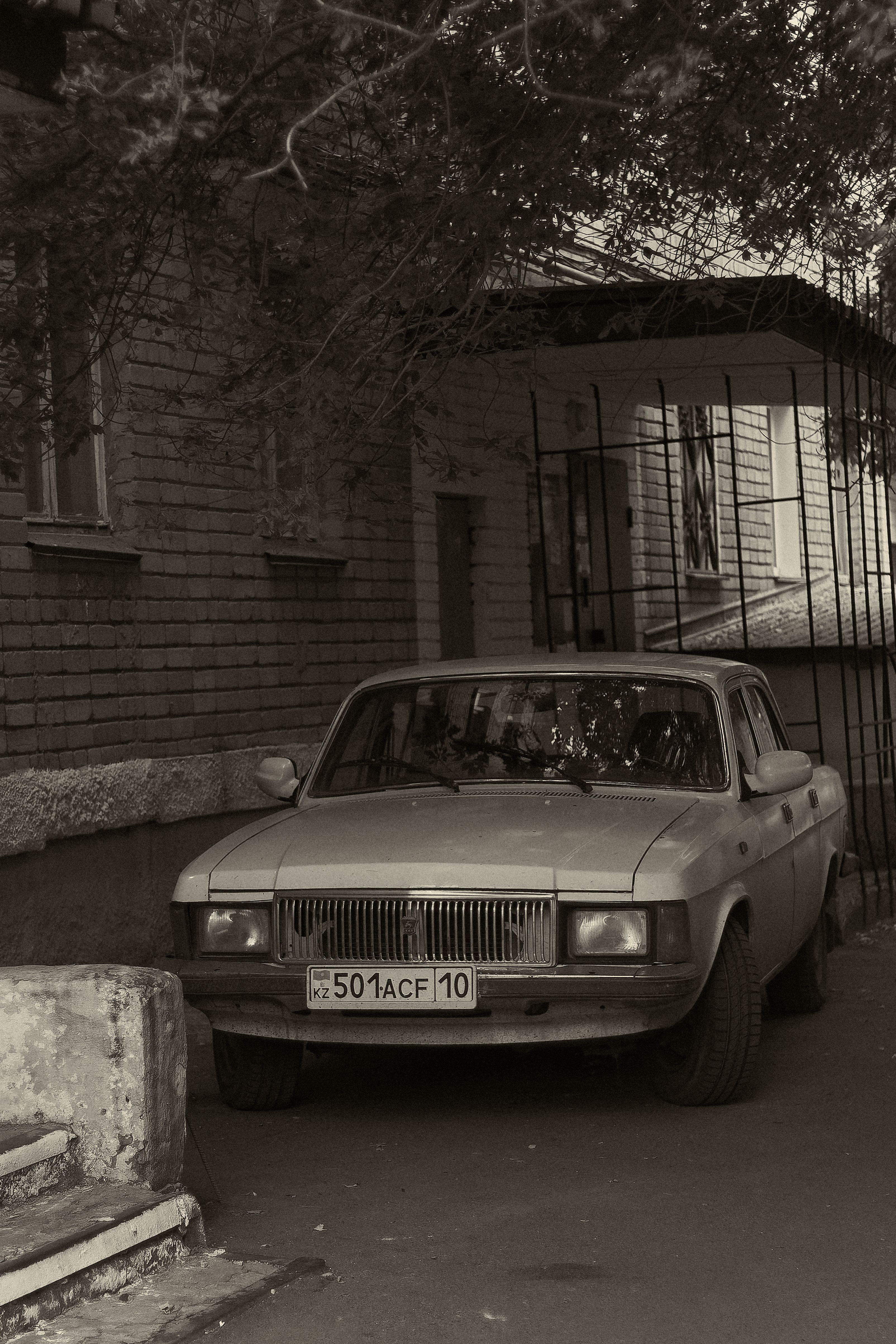 Vintage Car Parked Near Brick Building · Free Stock Photo