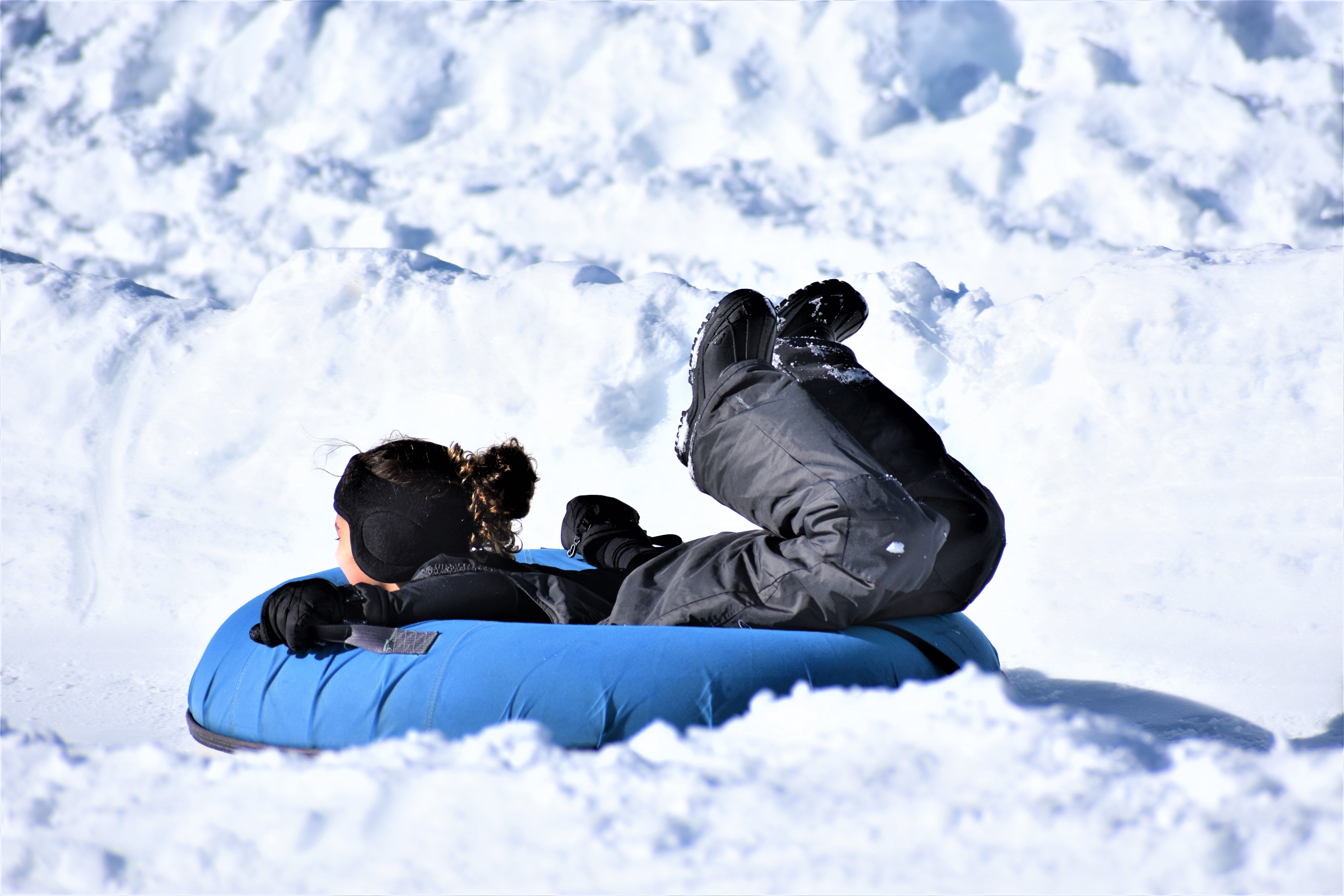 Child Enjoying Snow Tubing Adventure Outdoors · Free Stock Photo