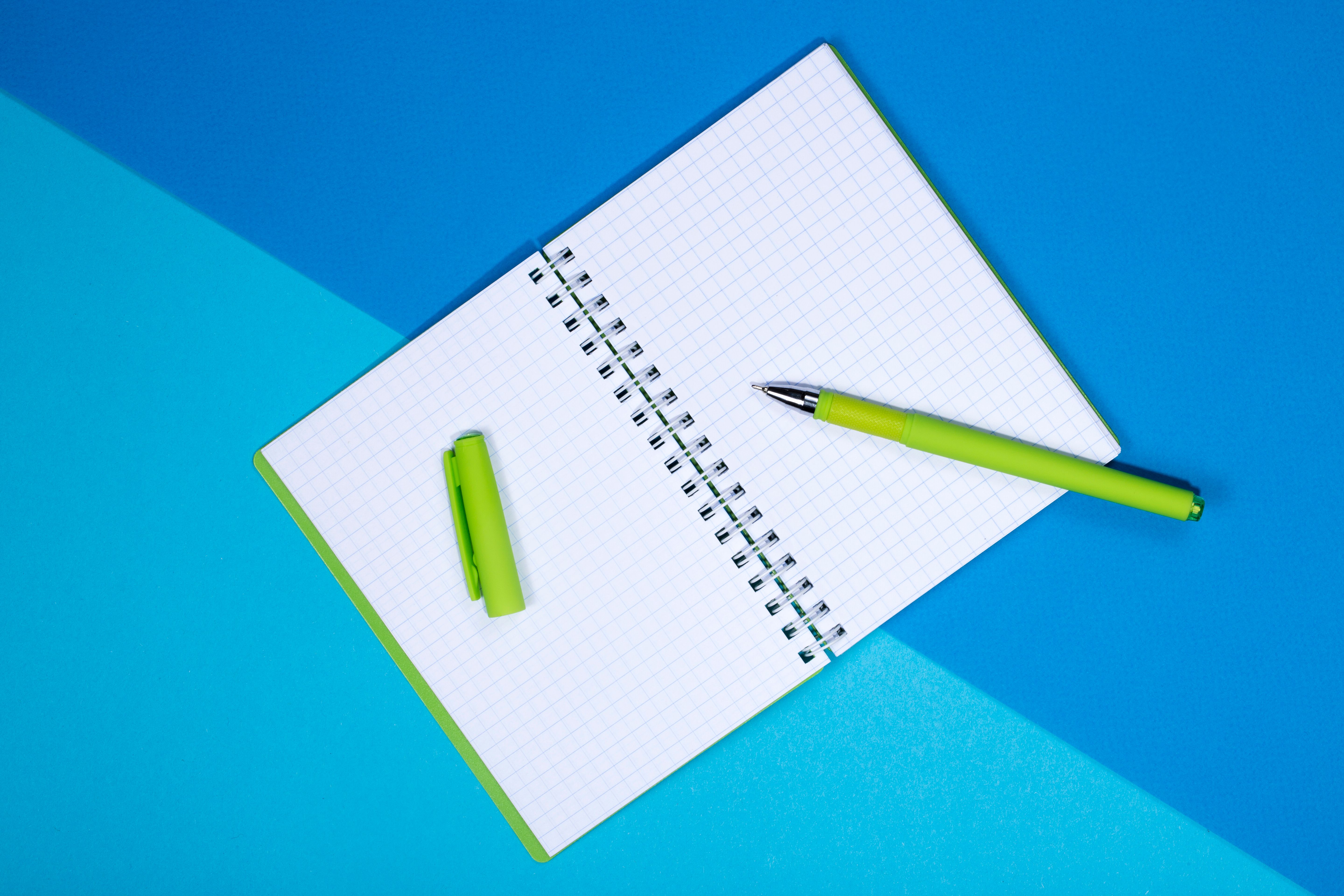 Green and Silver Push Pen on White Ruled Paper Indoors · Free Stock Photo