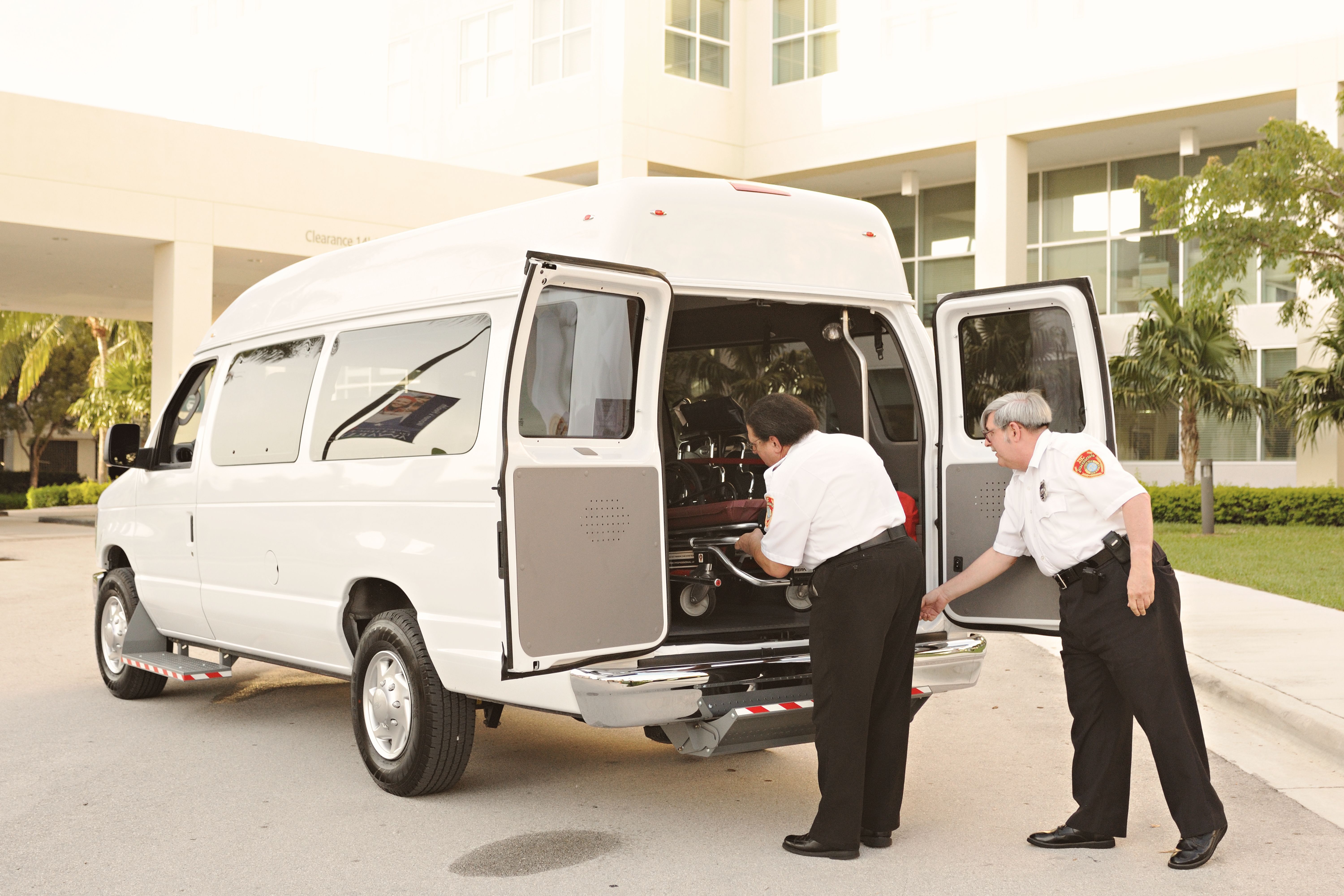 Emergency responders loading stretcher into ambulance · Free Stock Photo