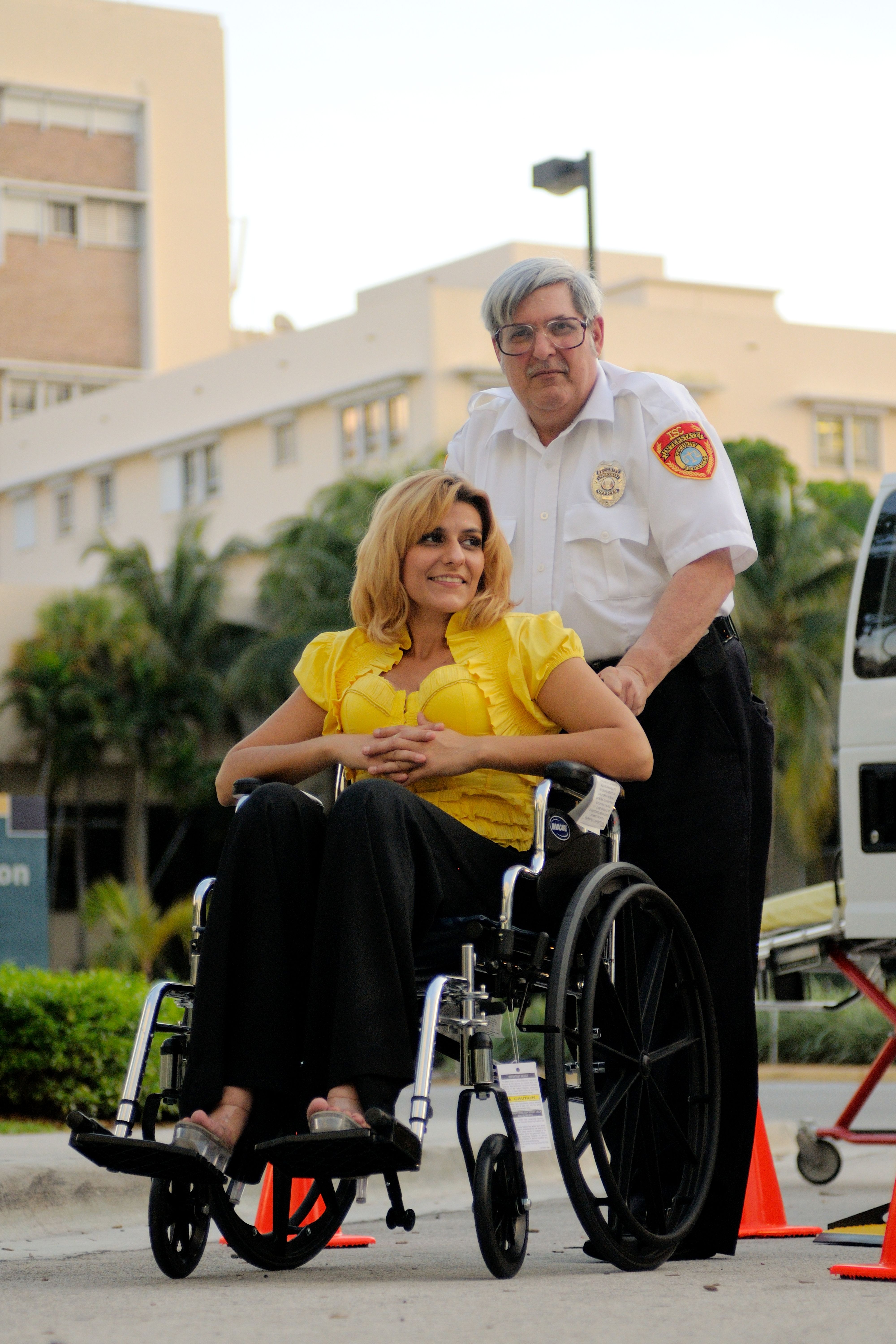Woman in Wheelchair with Security Officer Outdoors · Free Stock Photo
