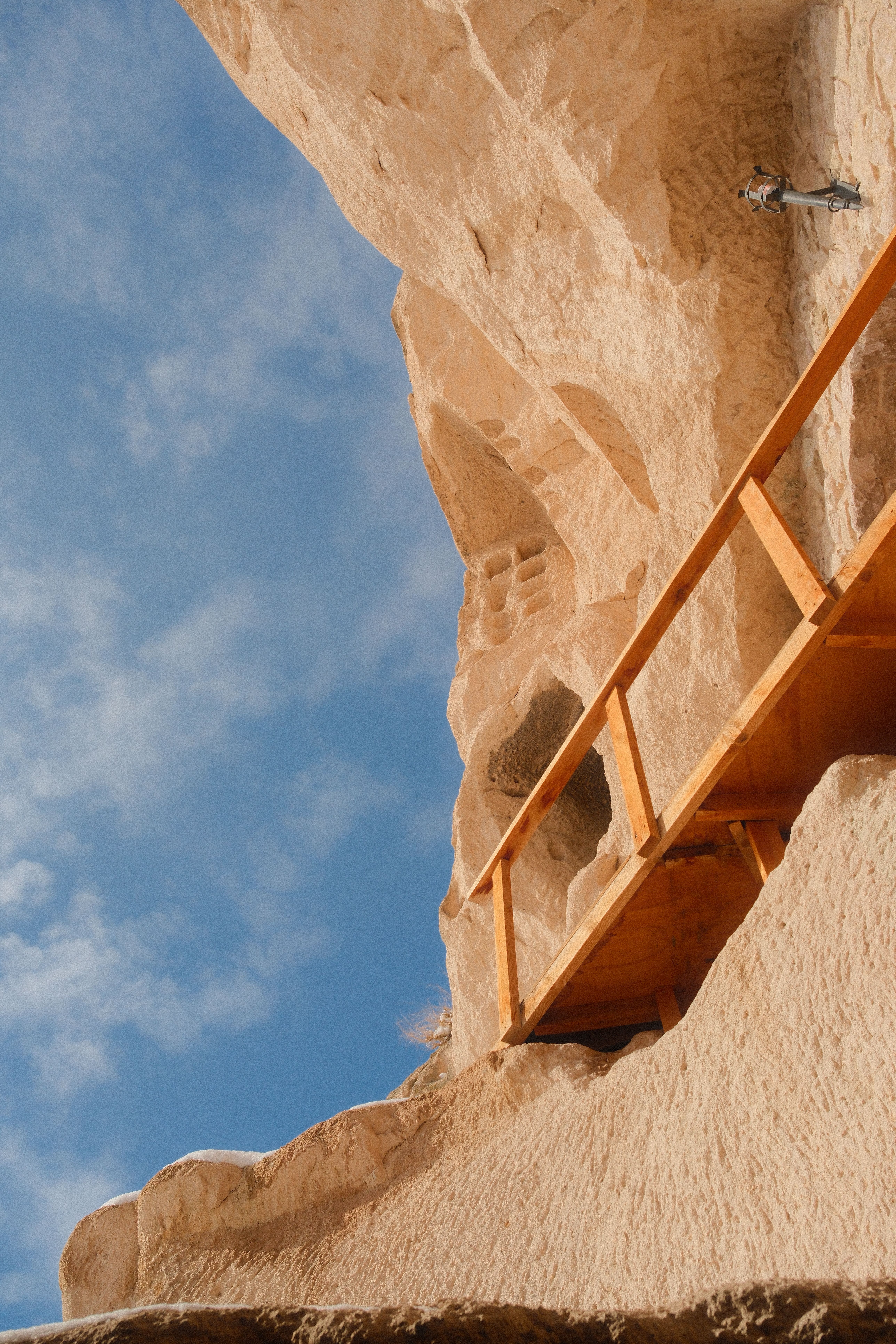Wooden Pathway Along Sandstone Cliff with Blue Sky · Free Stock Photo