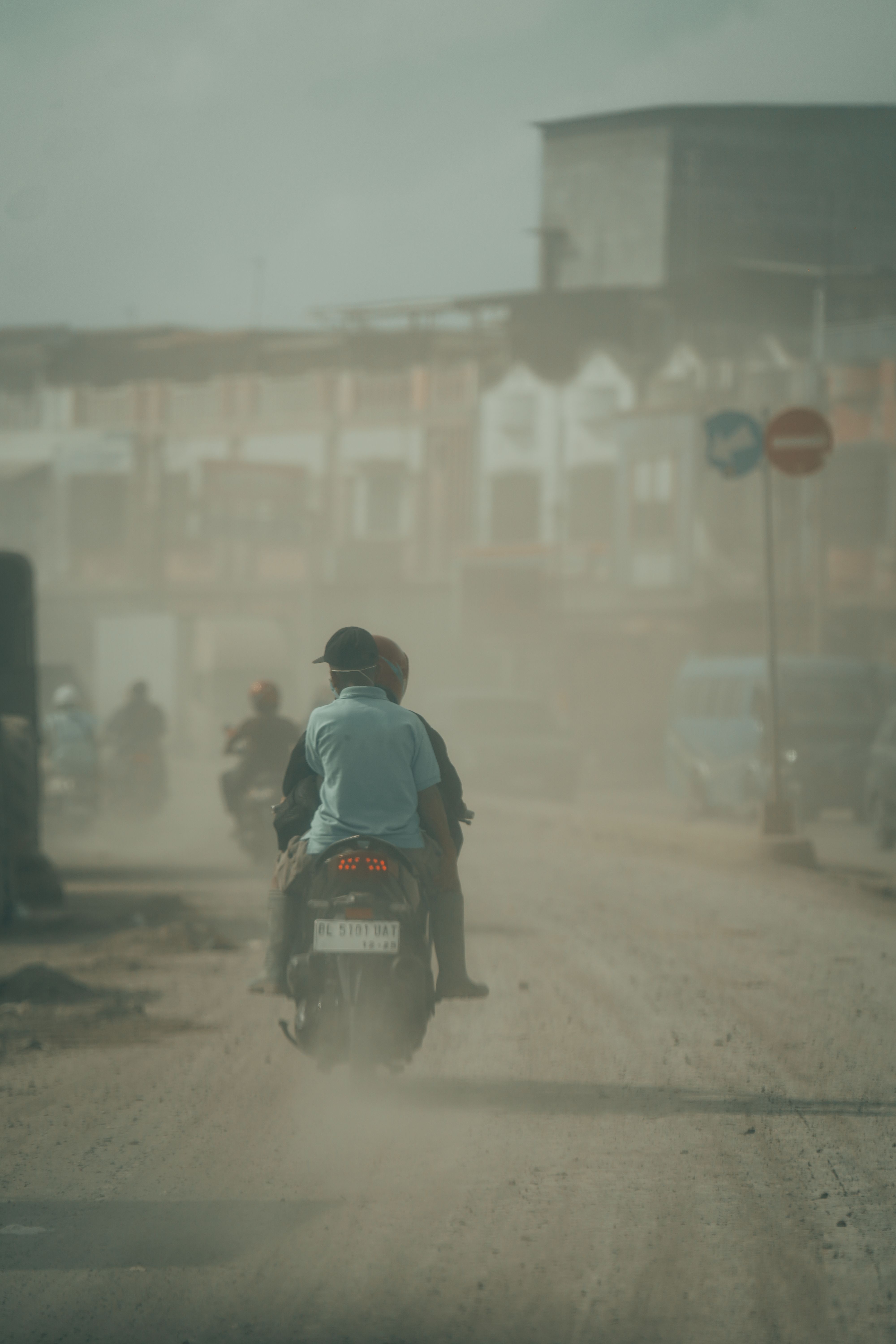 Dusty Street Scene in Aceh with Motorcyclists · Free Stock Photo
