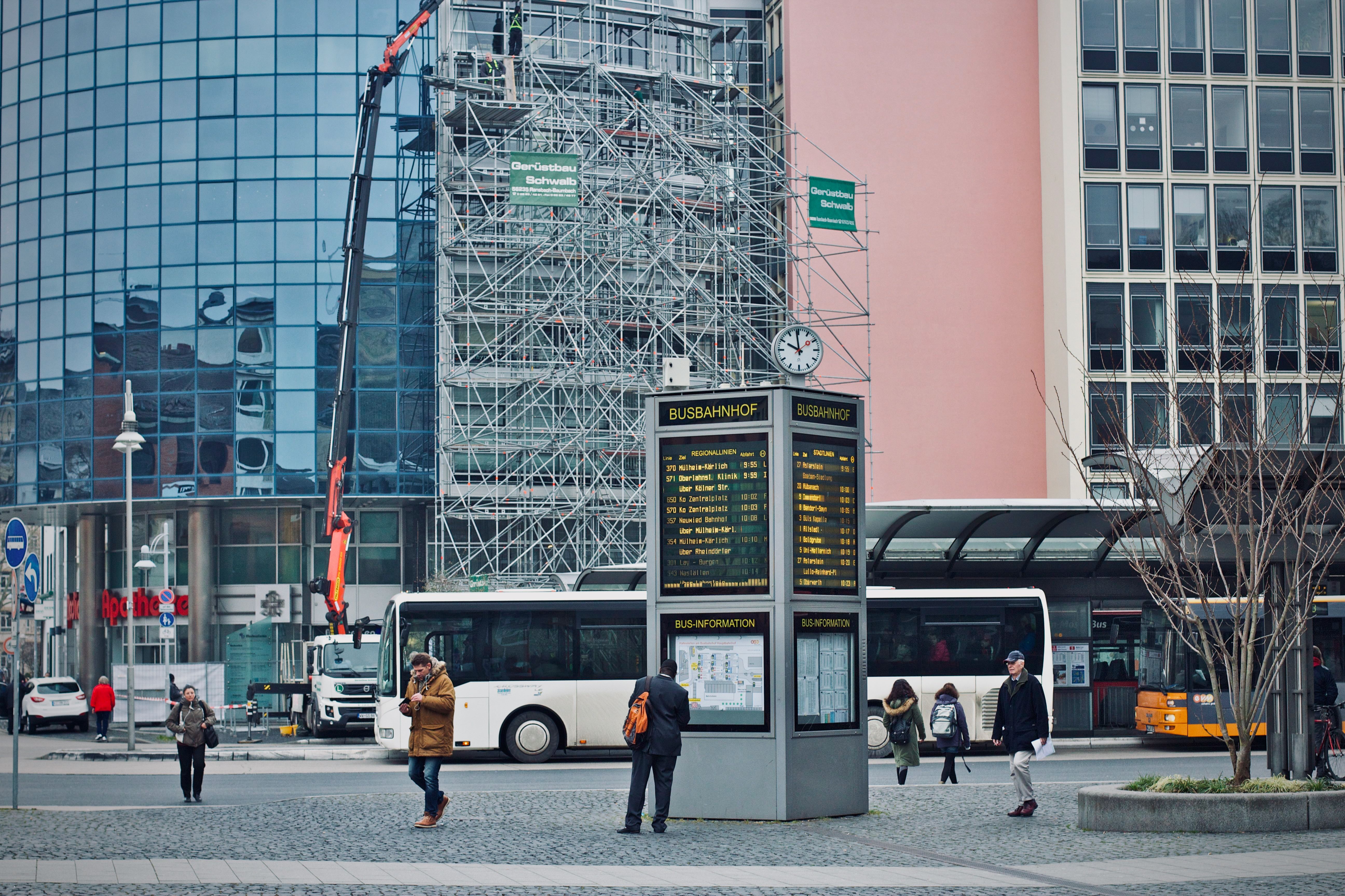 Urban Bus Station with Scaffolding and Commuters · Free Stock Photo