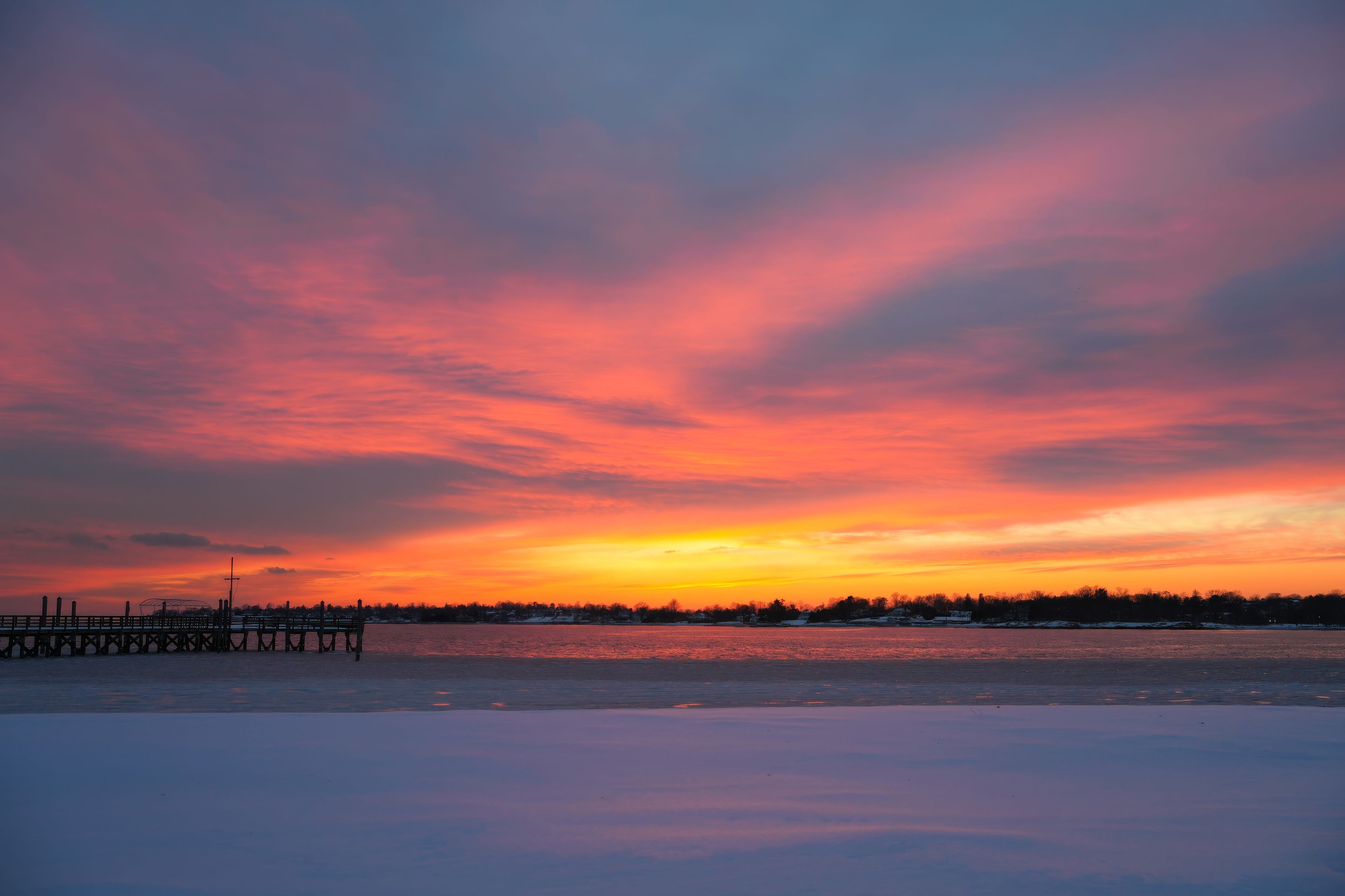 Vibrant Sunset Over Snowy Lakeside Pier · Free Stock Photo