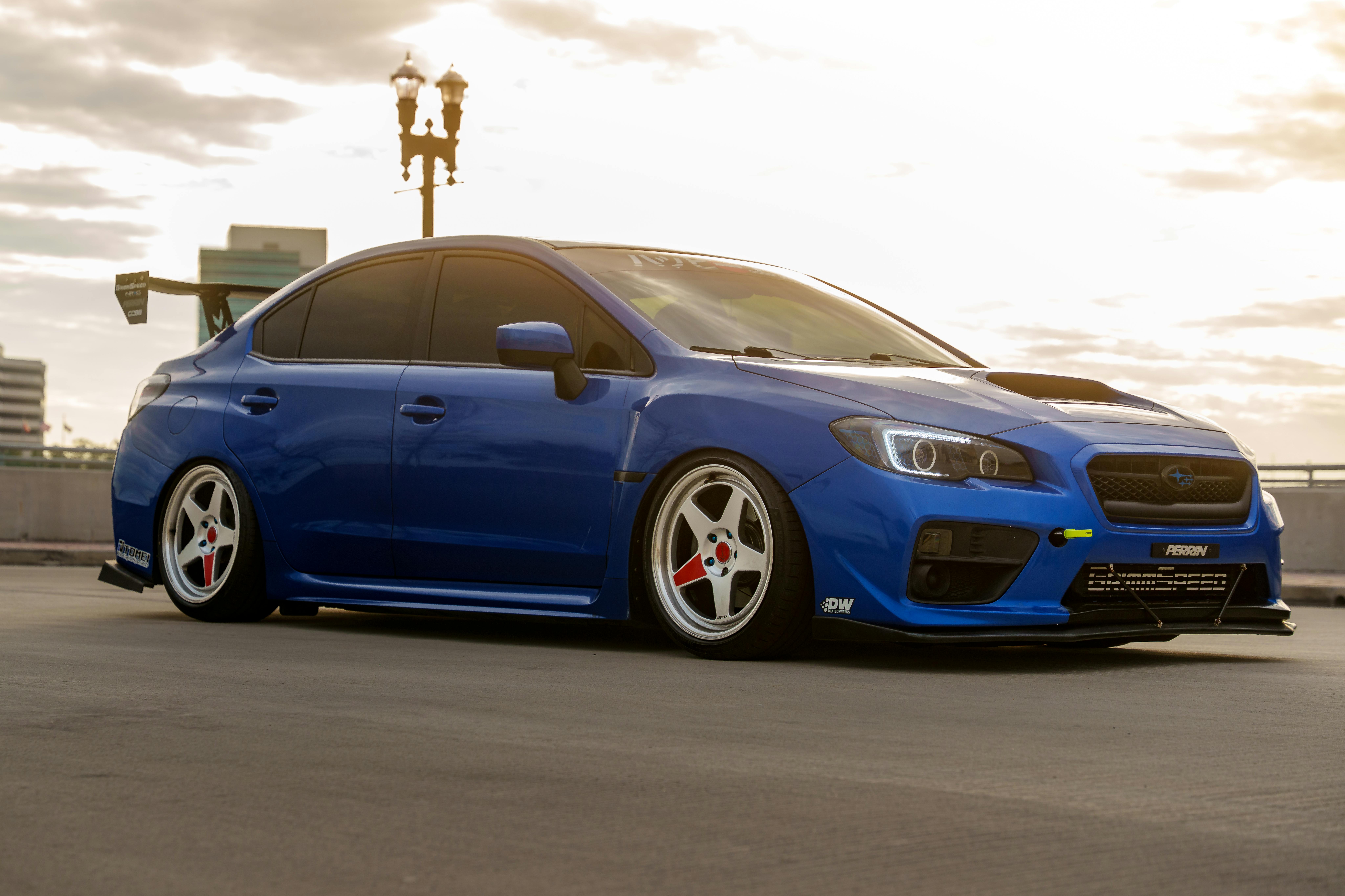 Blue Sports Car at Sunset on Urban Street · Free Stock Photo