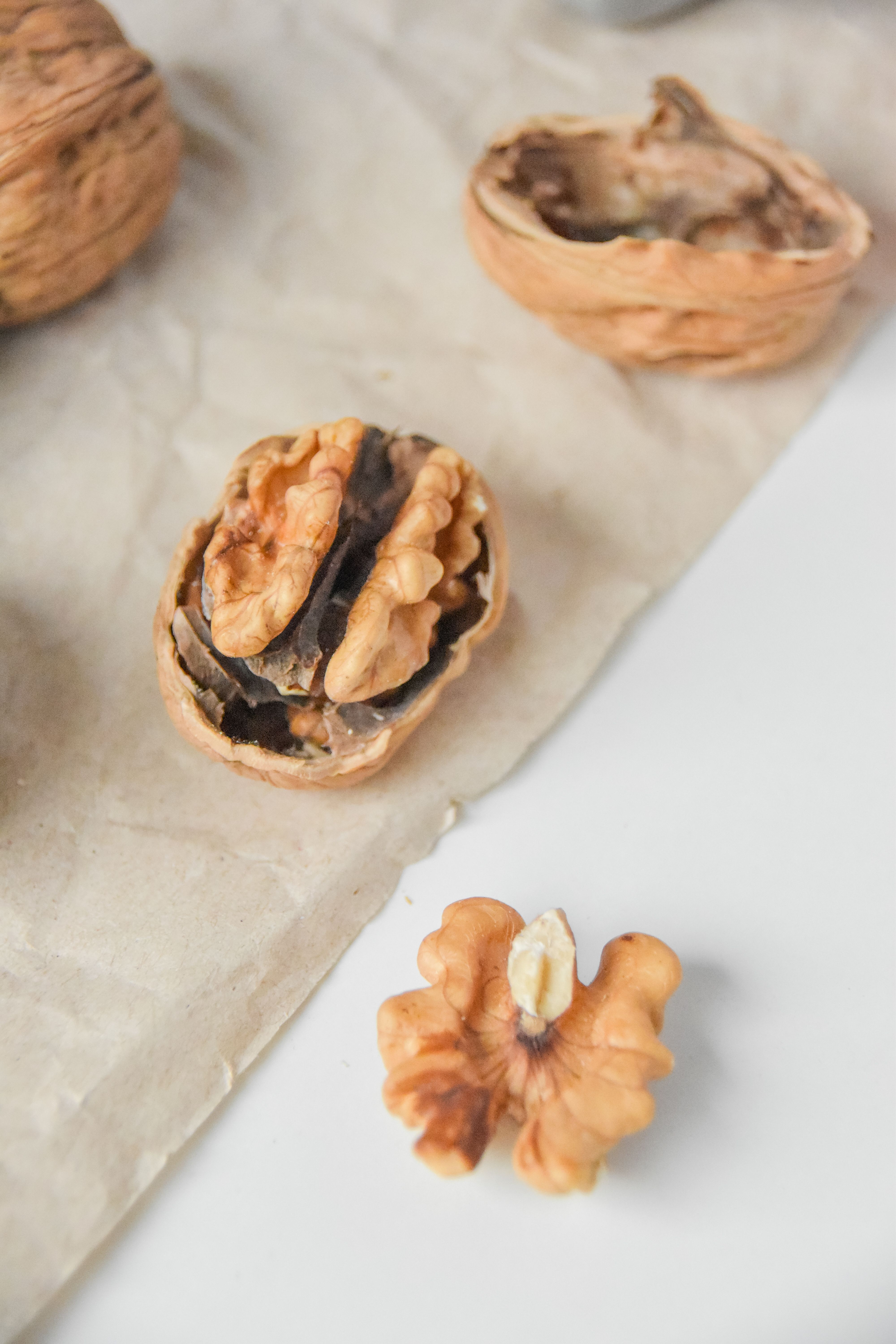 Close-Up of Walnuts on Parchment Paper · Free Stock Photo