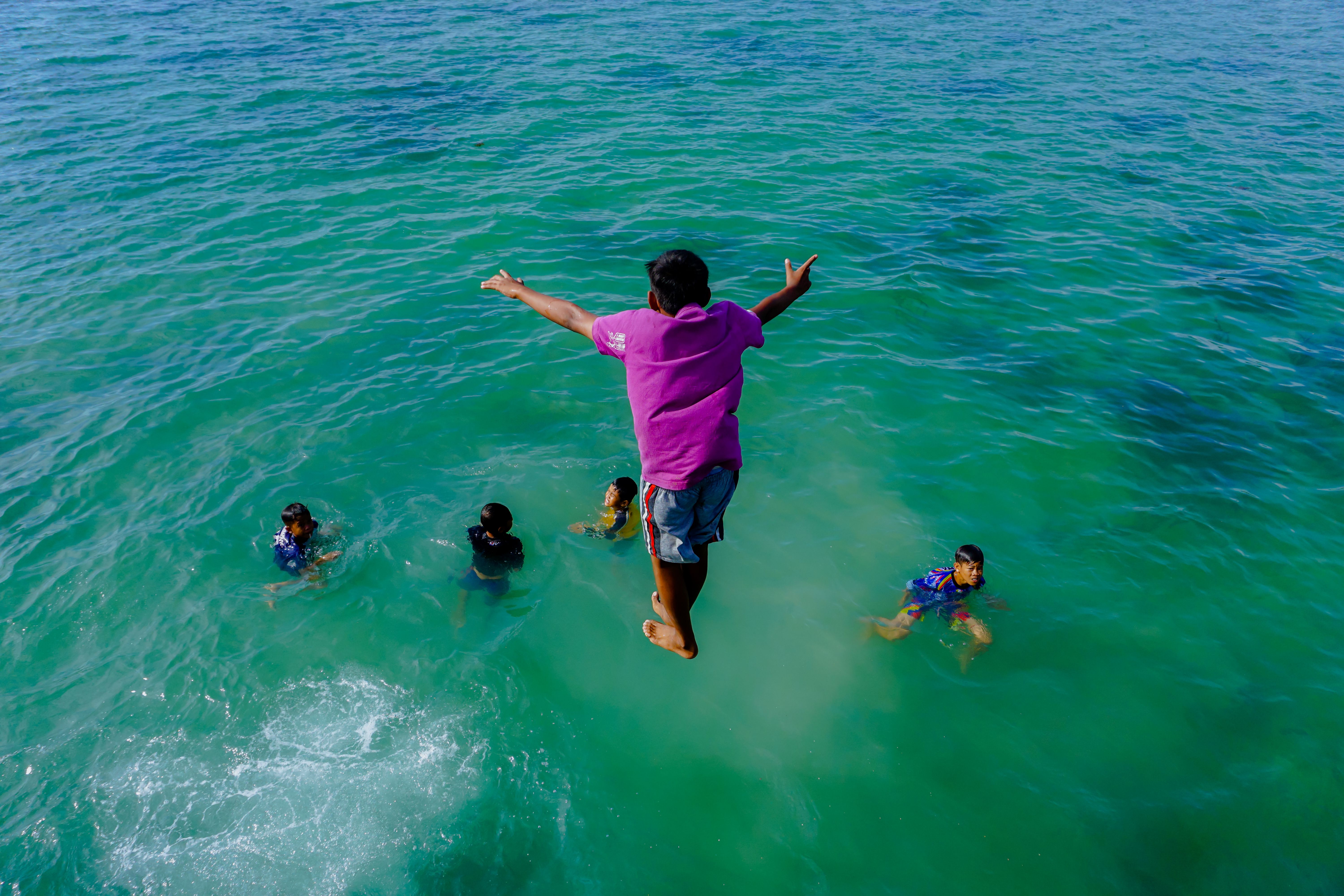 Group of Kids Jumping into the Ocean on a Sunny Day · Free Stock Photo