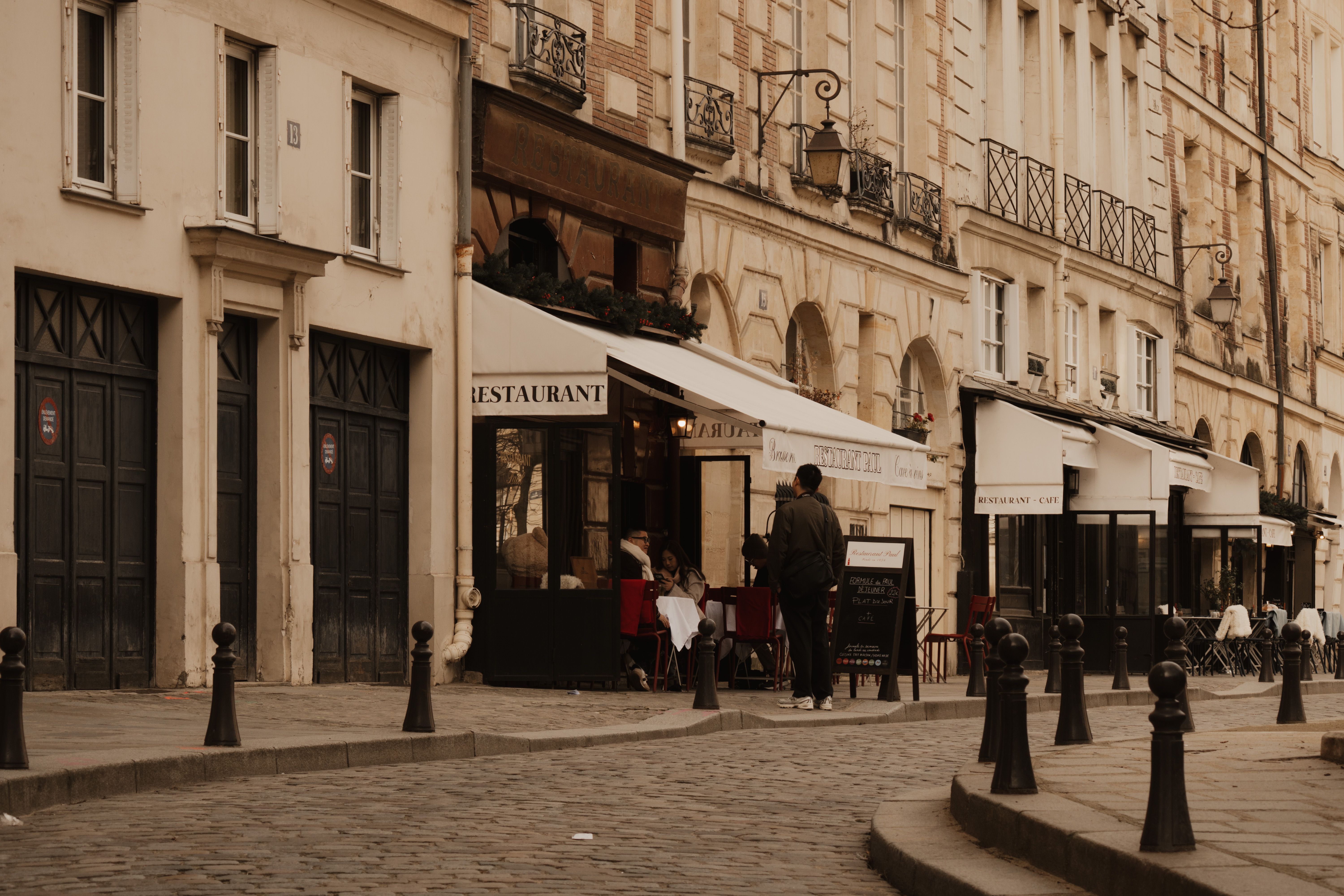 Charming Parisian Street with Sidewalk Cafes · Free Stock Photo