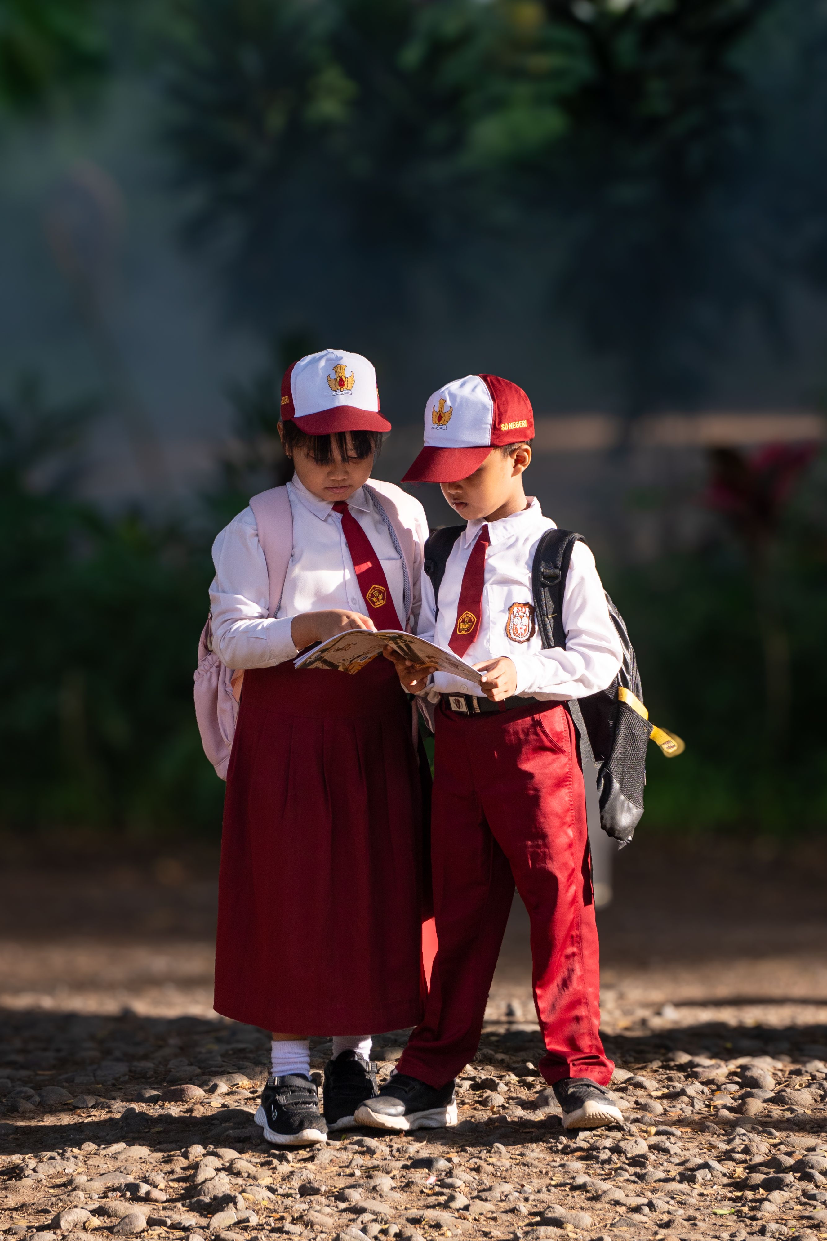 Young Students in School Uniforms Reading Outdoors · Free Stock Photo