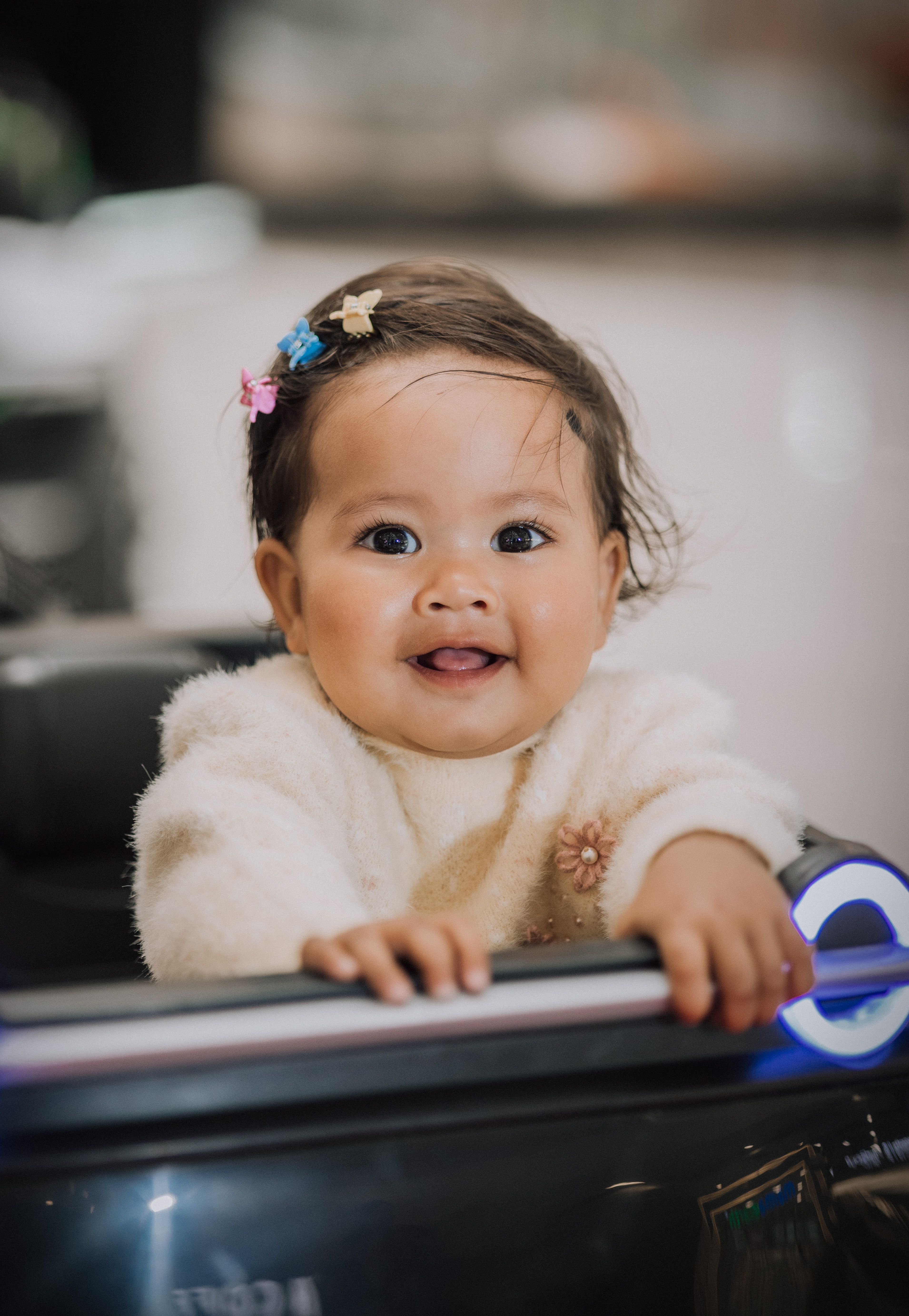 Adorable Baby with Hair Clips Smiling Indoors · Free Stock Photo