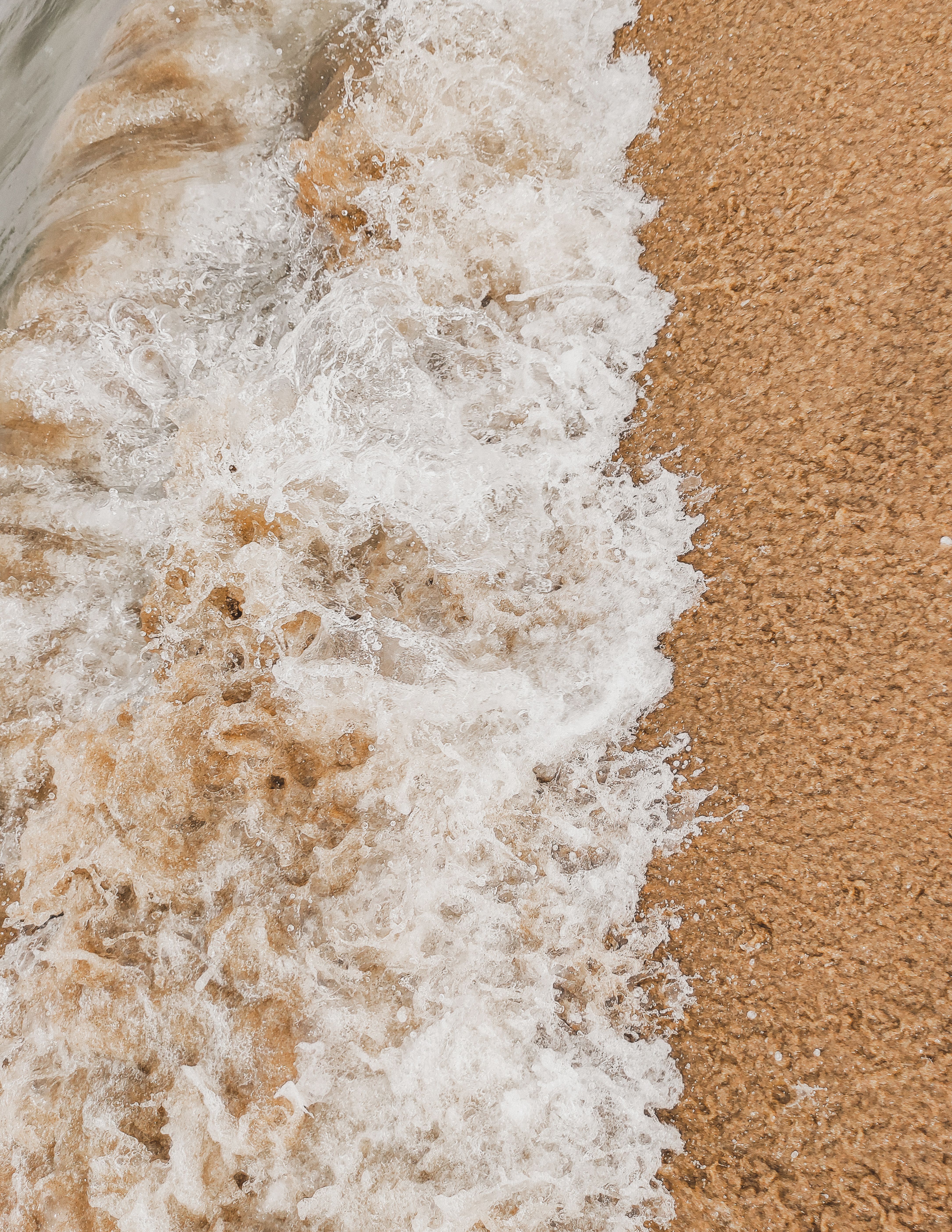 Close-up of Ocean Wave Crashing on Sandy Shore · Free Stock Photo