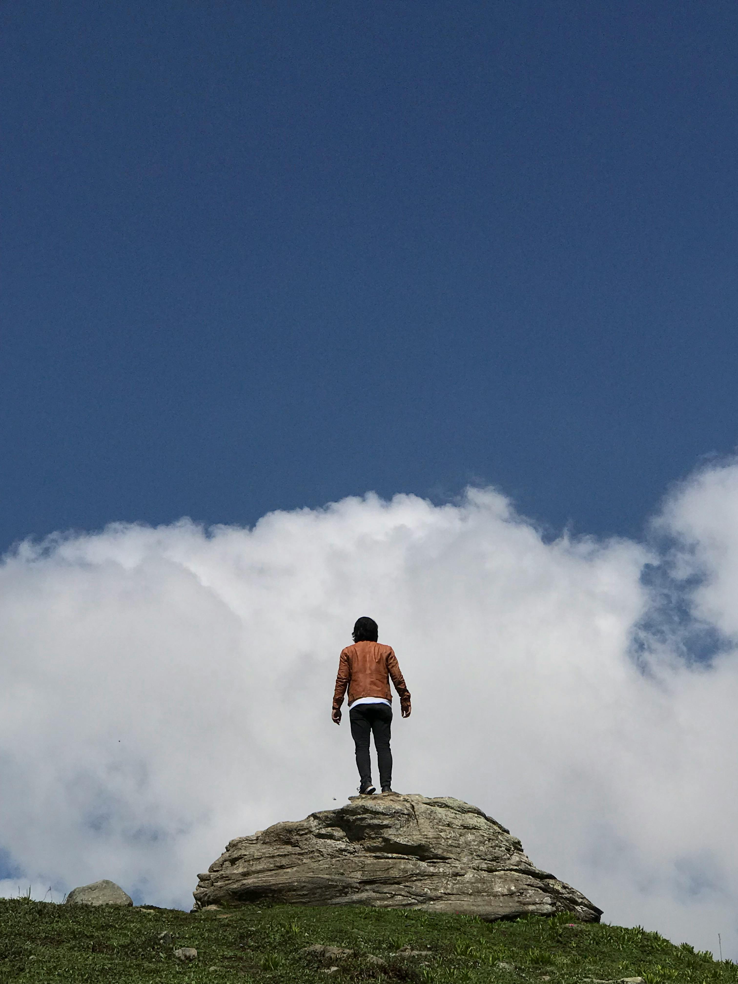 Person Standing On A Rock Under Blue Sky · Free Stock Photo