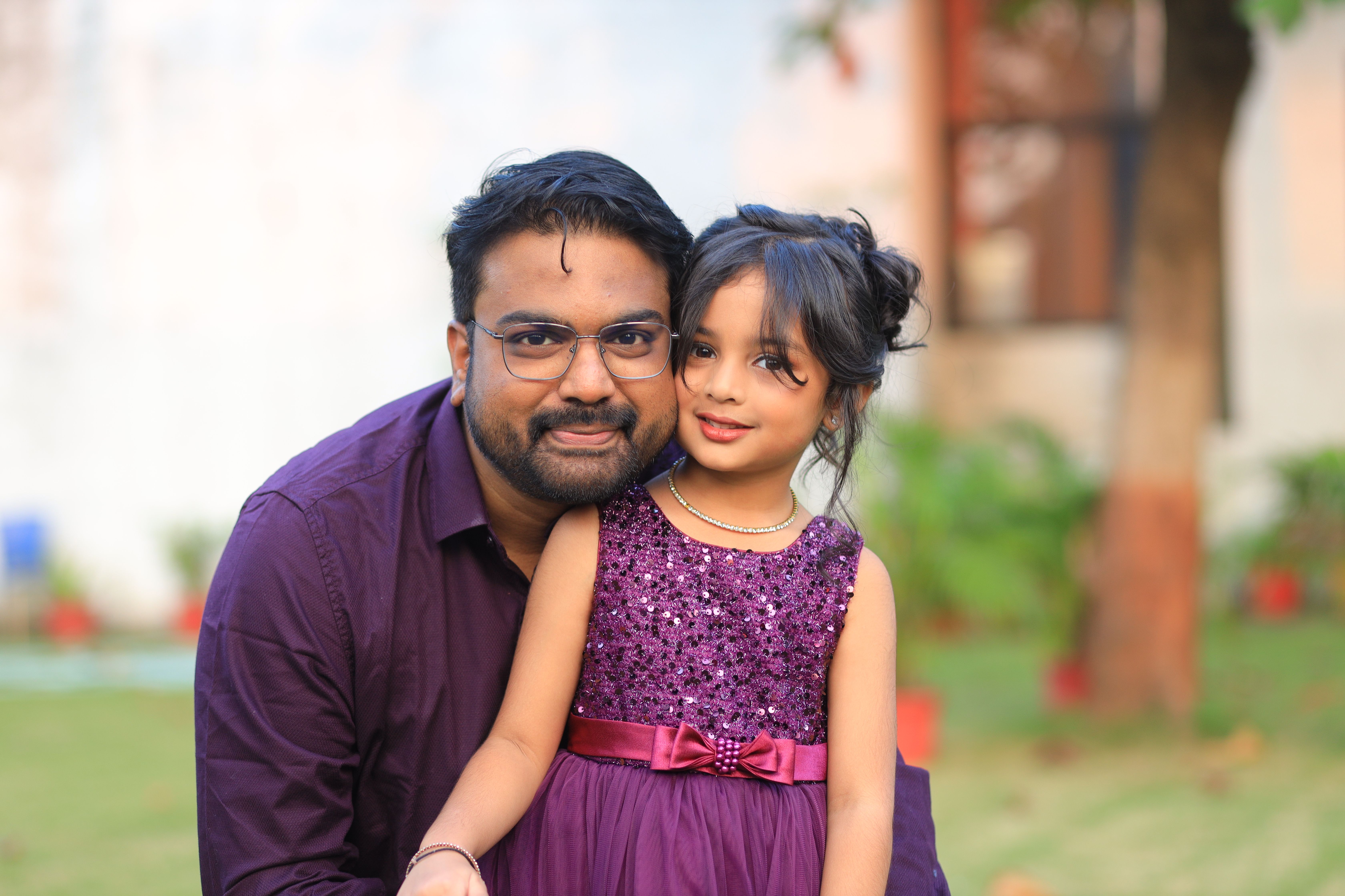 Father and Daughter Outdoor Portrait in Purple Attire · Free Stock Photo