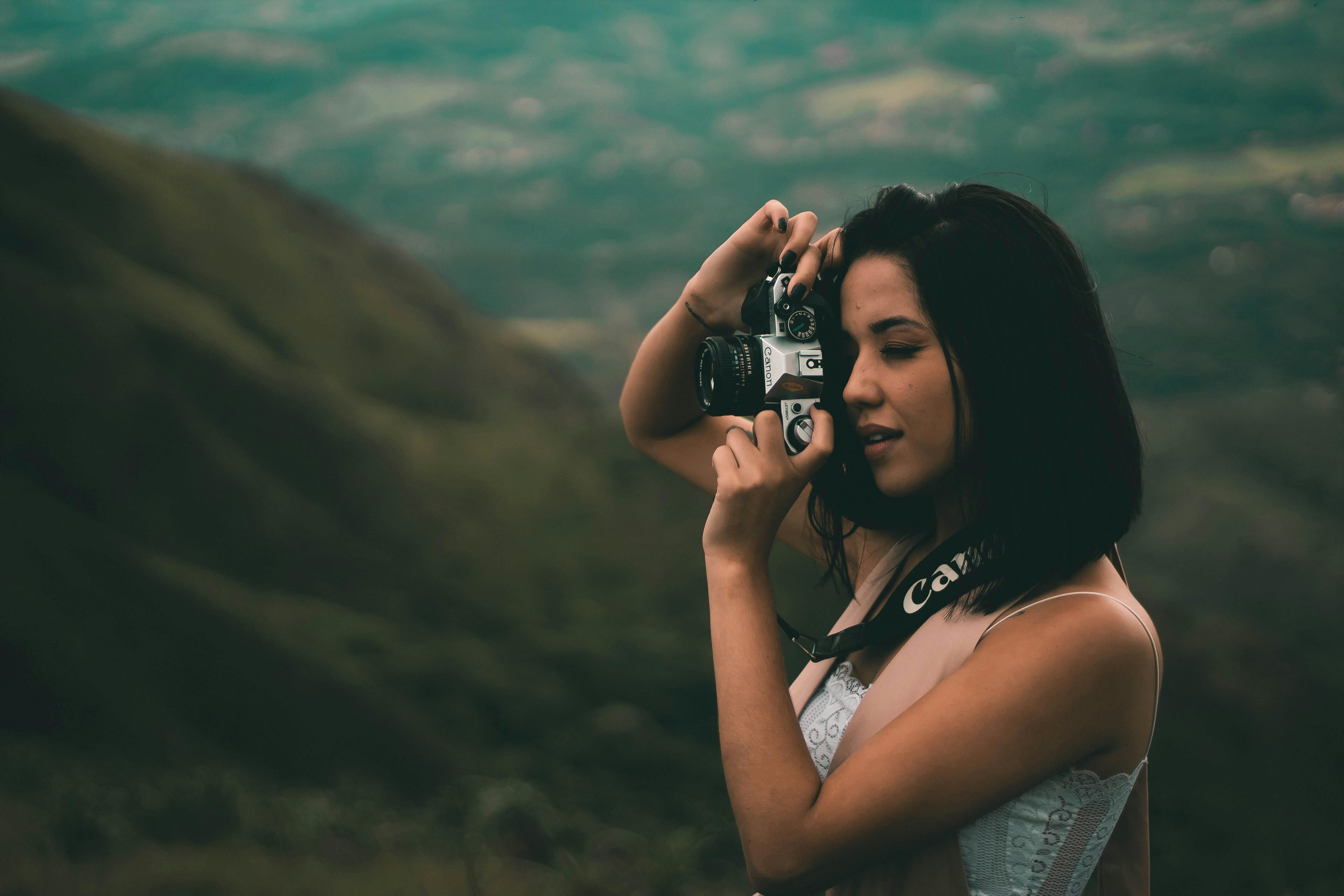 Woman Holding A Black Dslr Camera And Taking A Picture · Free Stock Photo