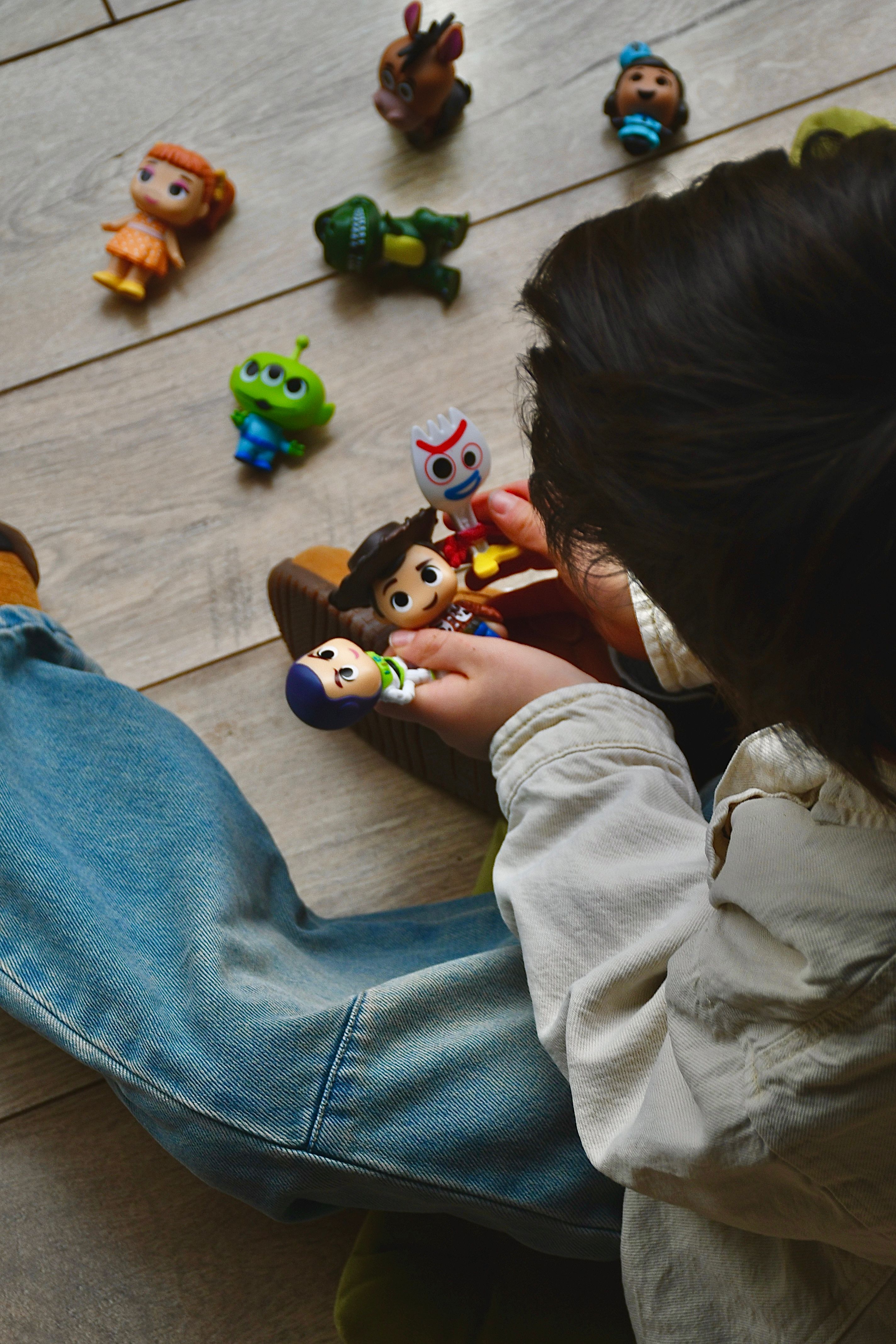 Child Playing with Toy Story Action Figures · Free Stock Photo