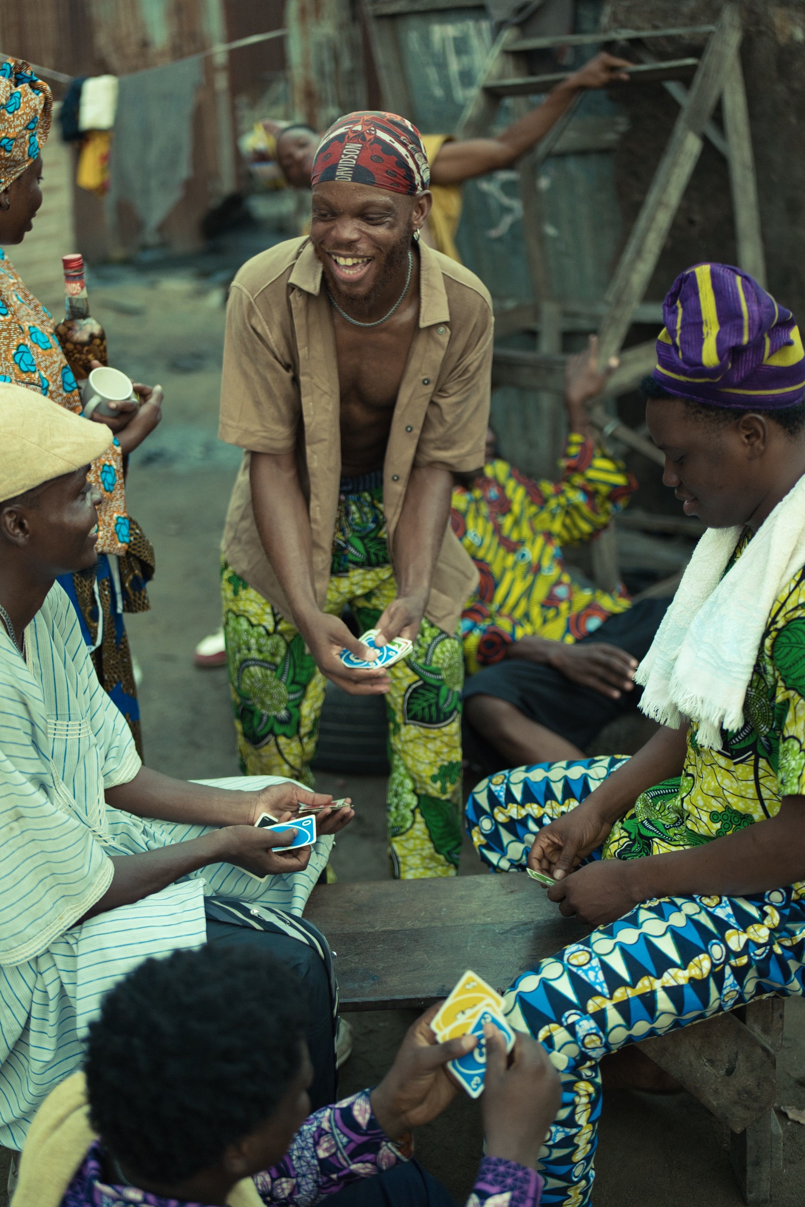 Joyful Group Playing Cards in Outdoor Setting · Free Stock Photo