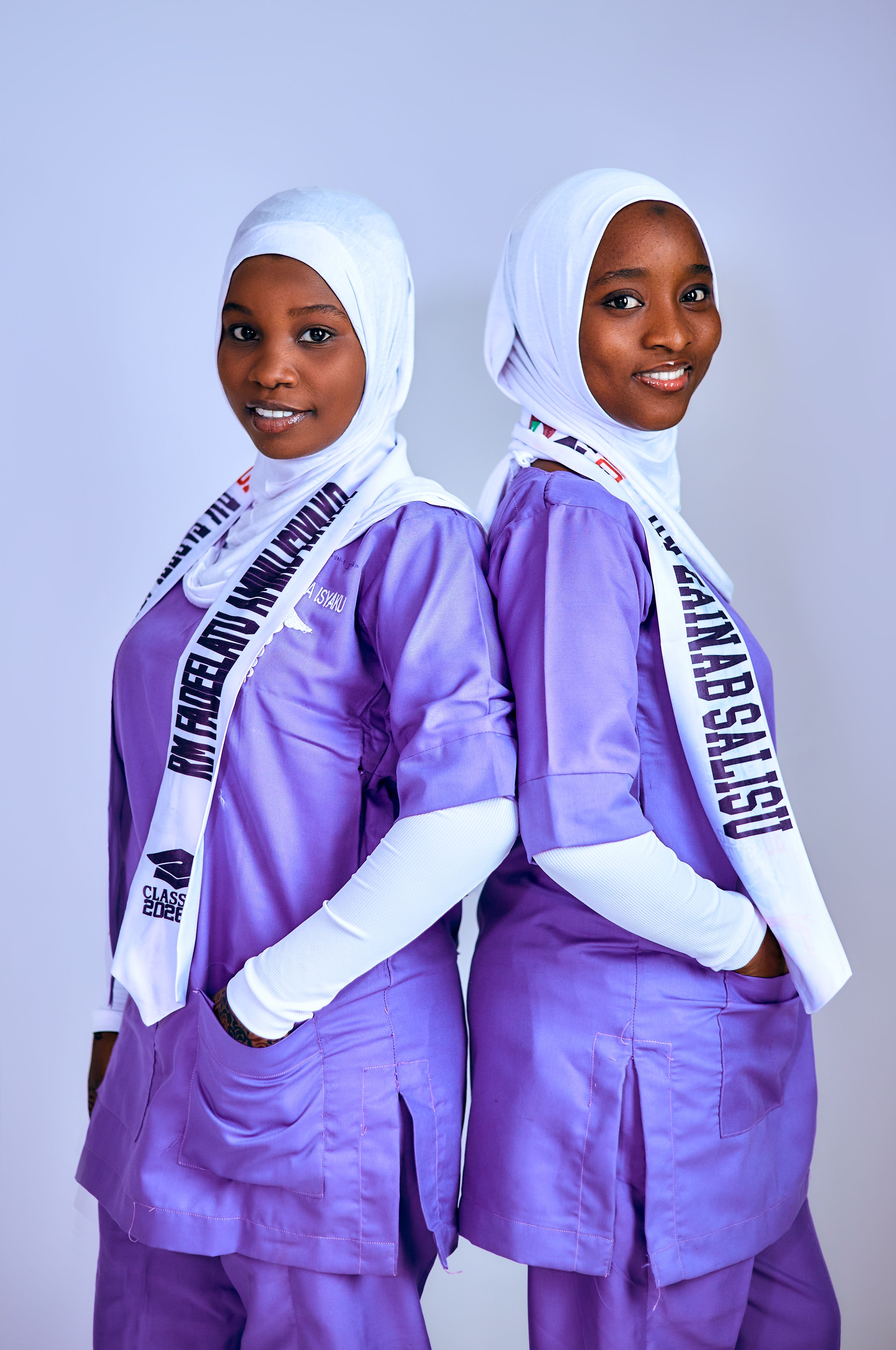 Two Women in Purple Uniforms with Hijabs Smiling · Free Stock Photo