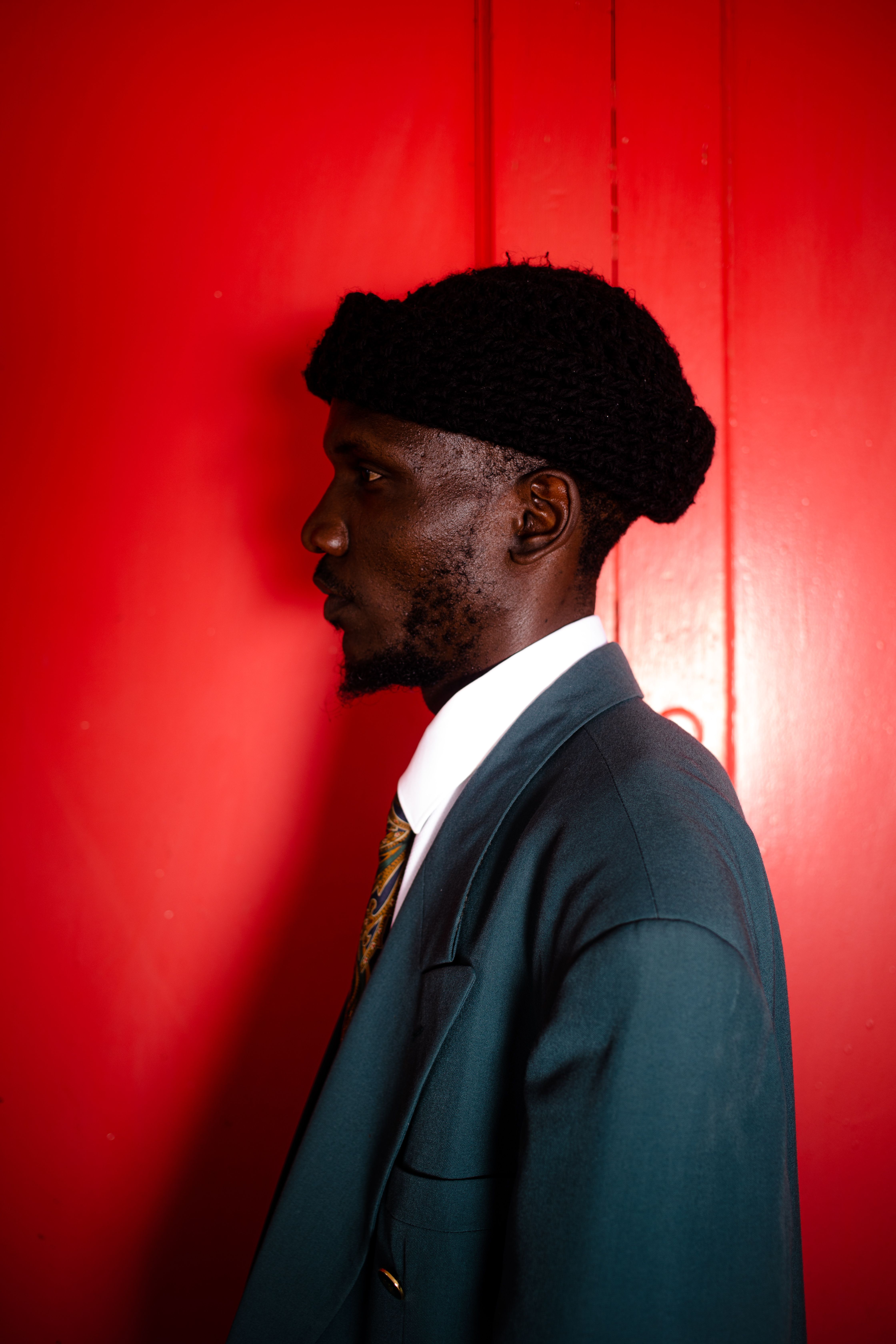 Portrait De Profil D'un Homme En Costume Sur Fond Rouge · Photo gratuite