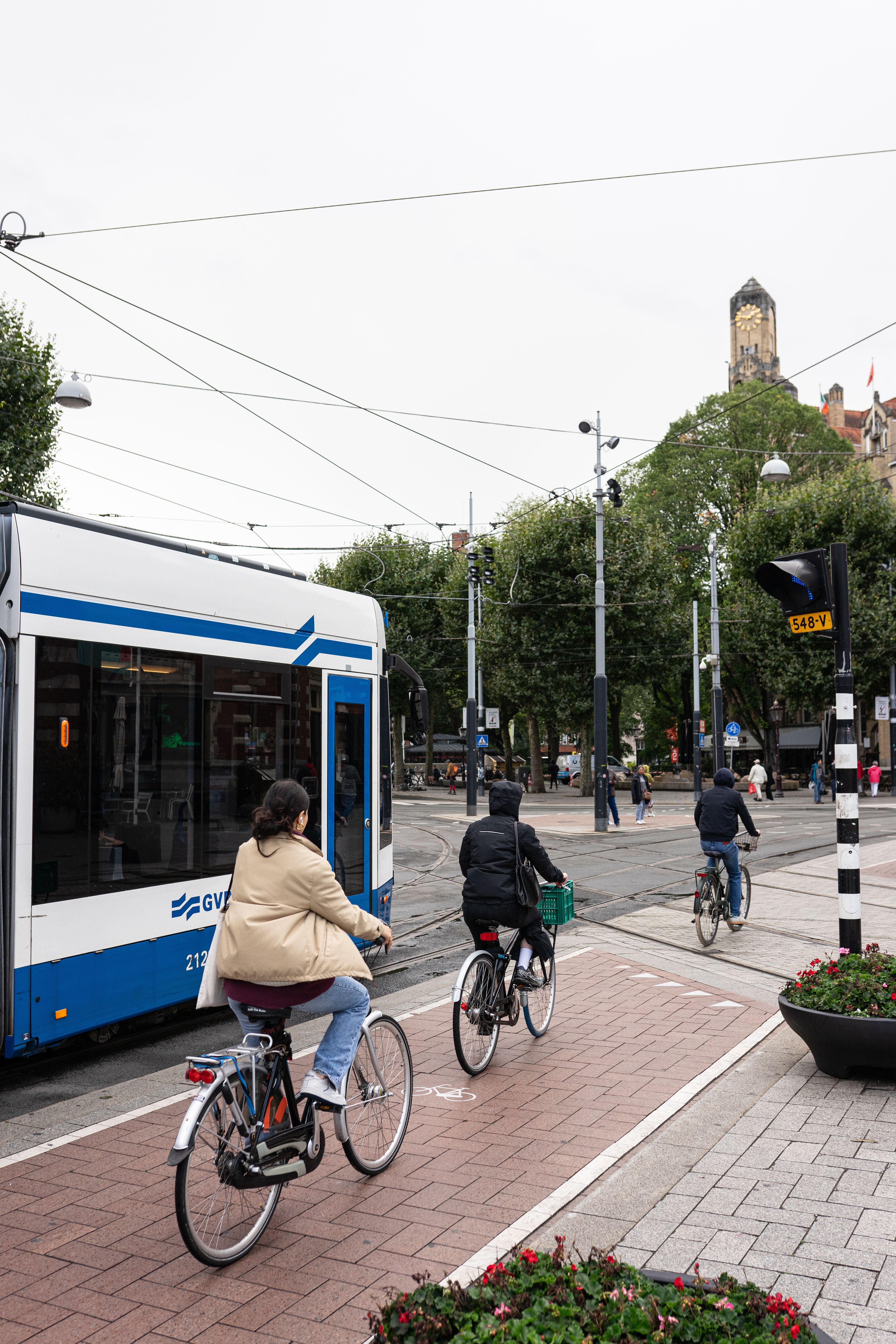 Cyclists and Tram in Amsterdam Intersection · Free Stock Photo