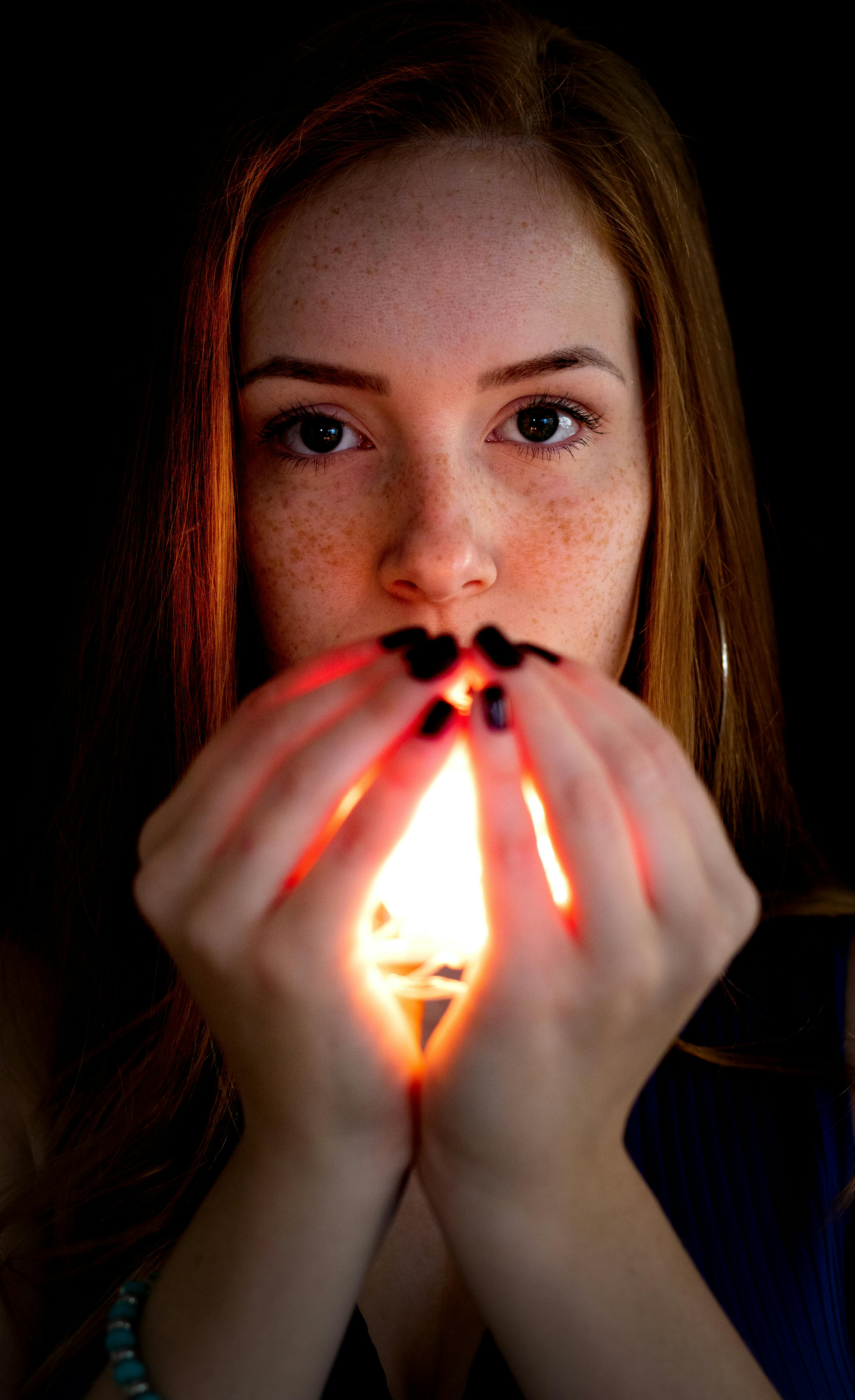 Woman Holding Lighted Candle in Front of Her Face · Free Stock Photo