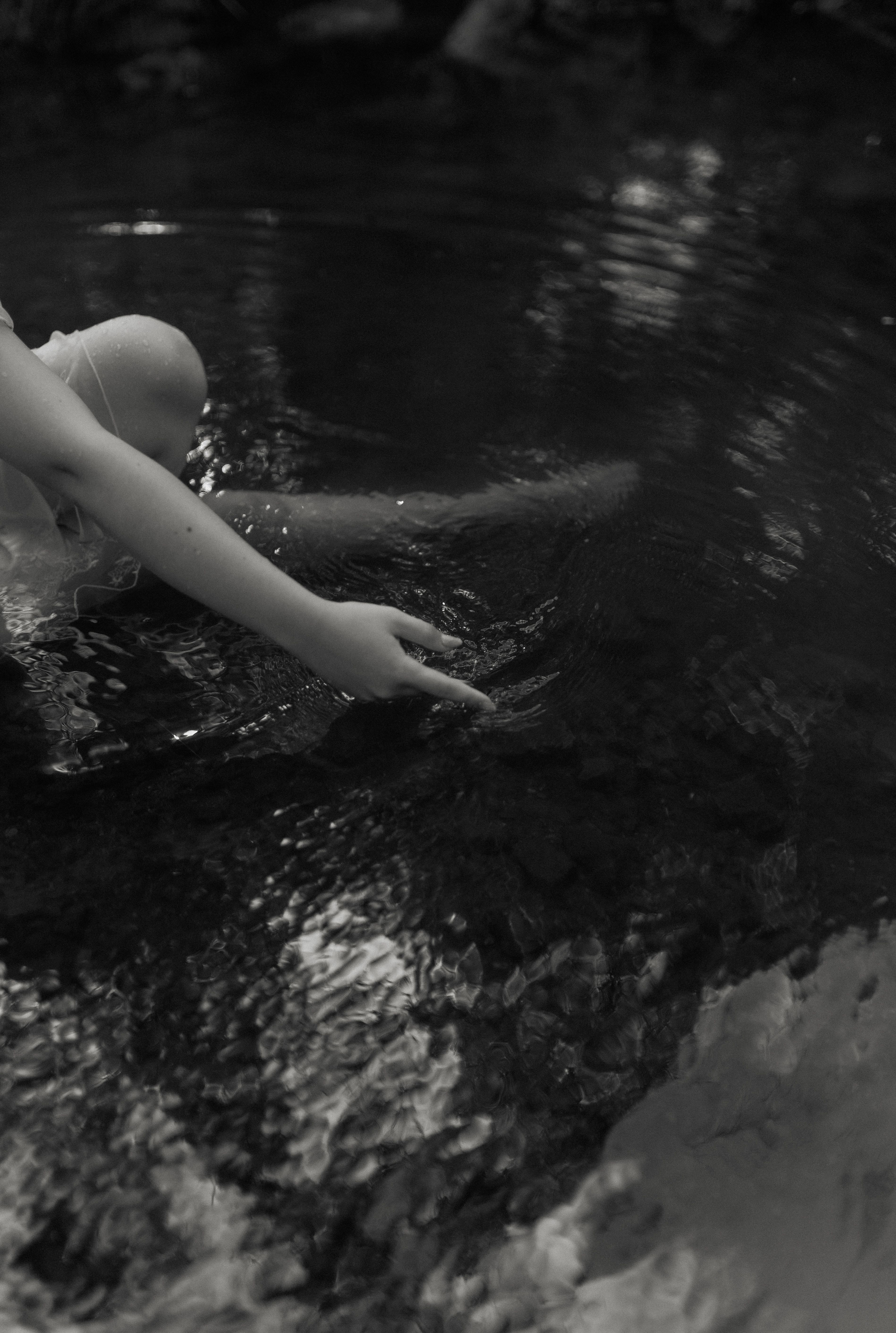 Child's Hand Touching Rippling Water in Stream · Free Stock Photo
