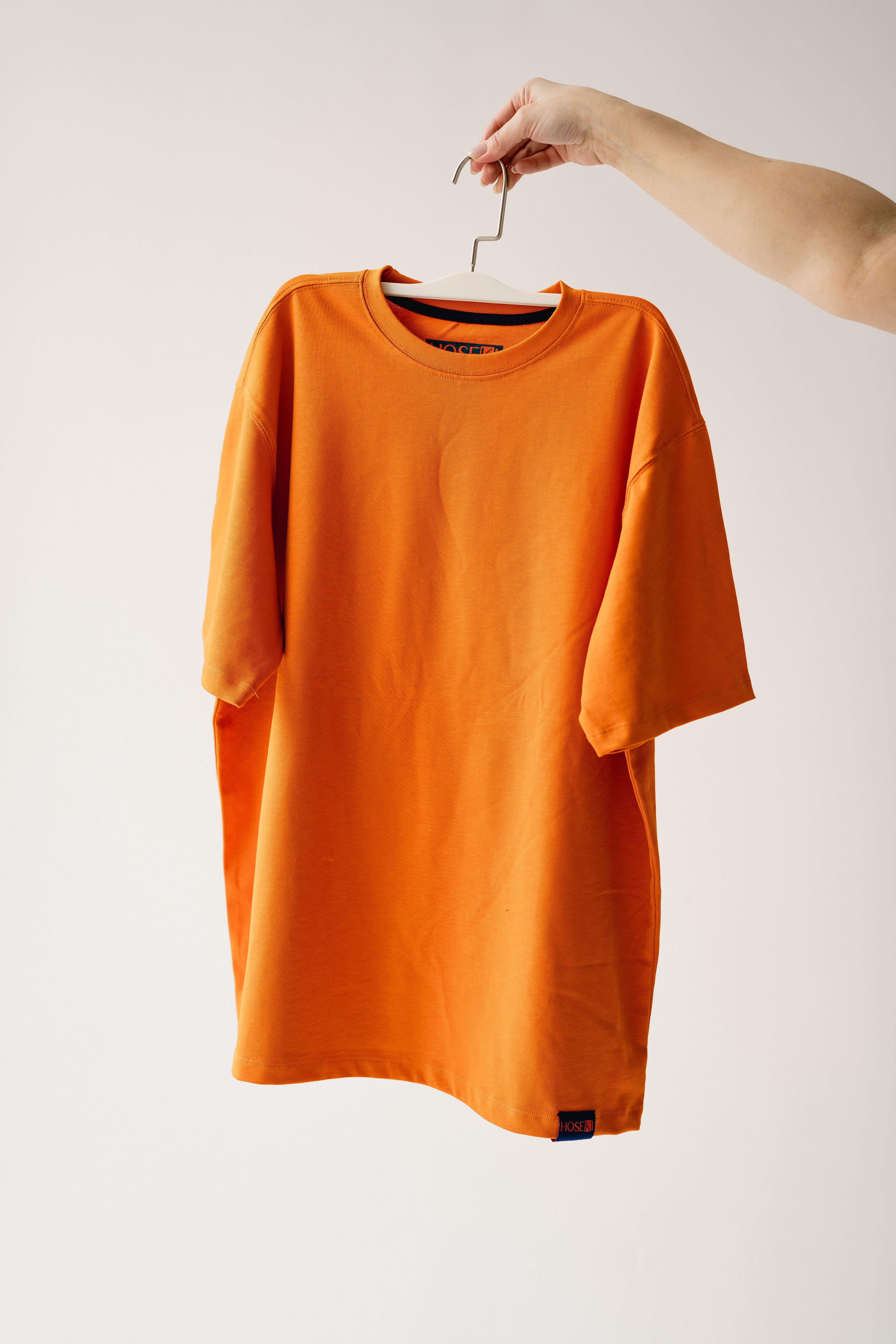 Hand Holds Hanger with T-shirt · Free Stock Photo