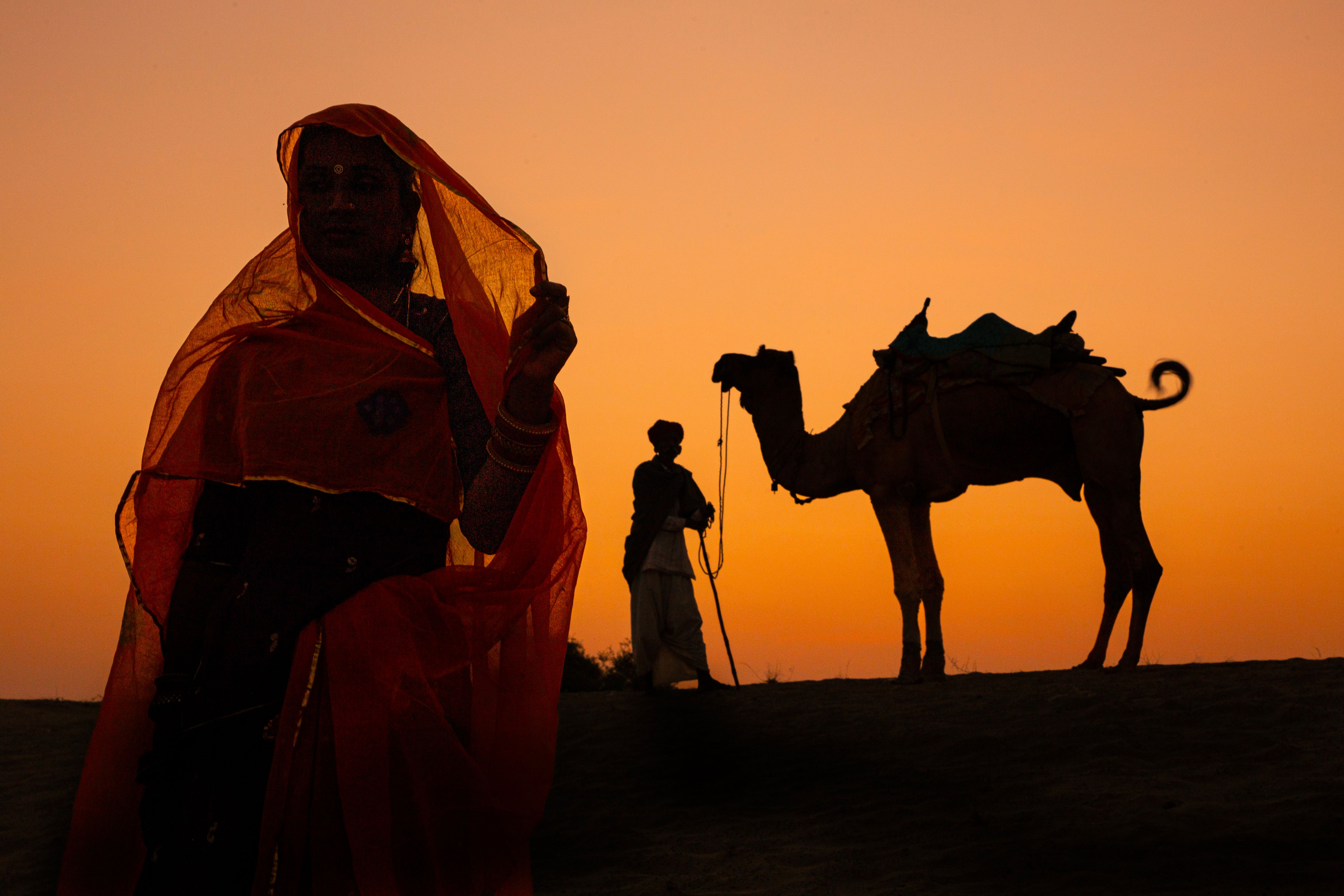 Silhouette D'un Nomade Du Désert Avec Un Chameau Au Coucher Du Soleil ...