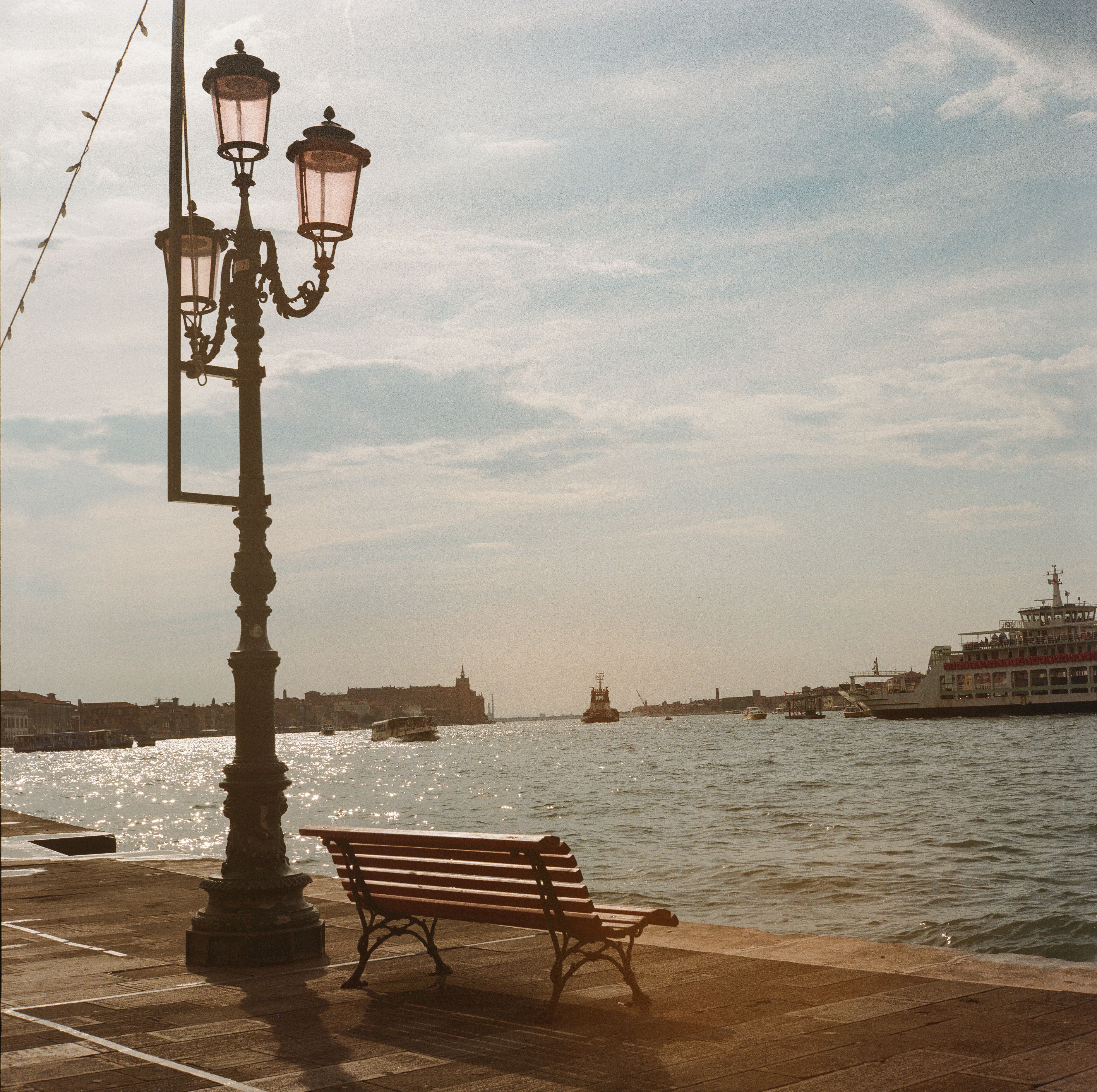 Sunlit Venice Waterfront with Historic Lamp Post · Free Stock Photo