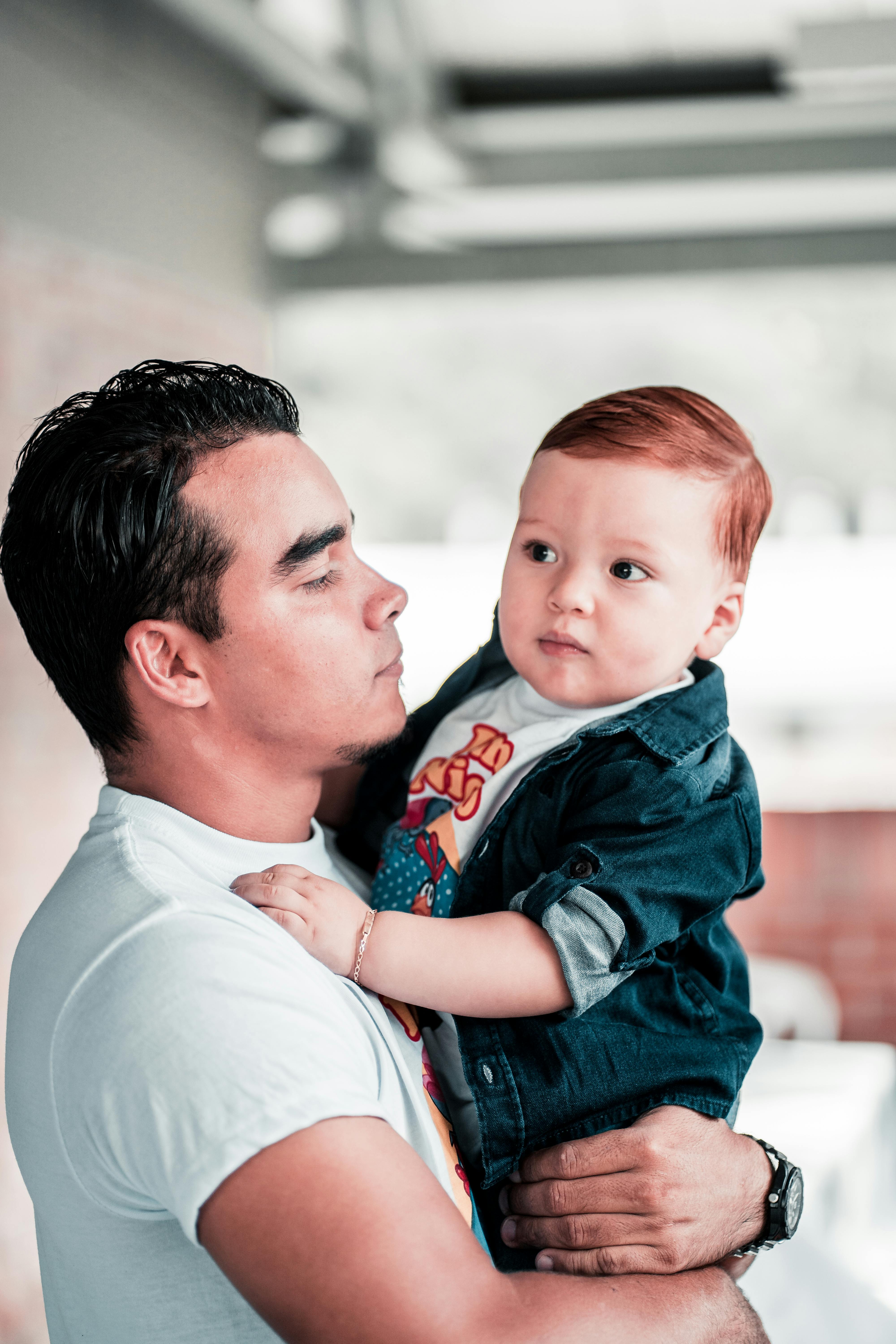 Photo Of Man Carrying Newborn Baby · Free Stock Photo