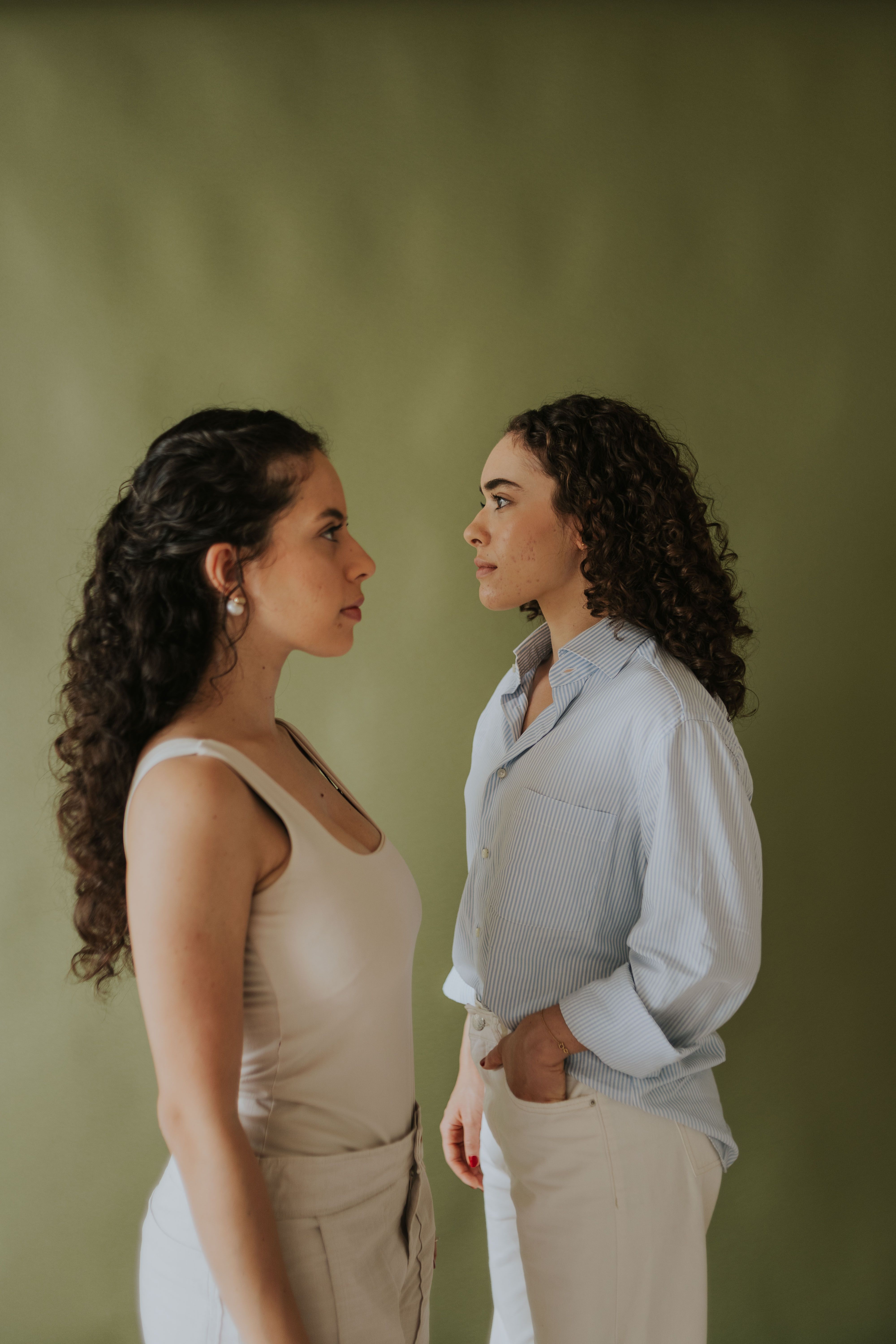 Portrait of Two Women Facing Each Other Indoors · Free Stock Photo