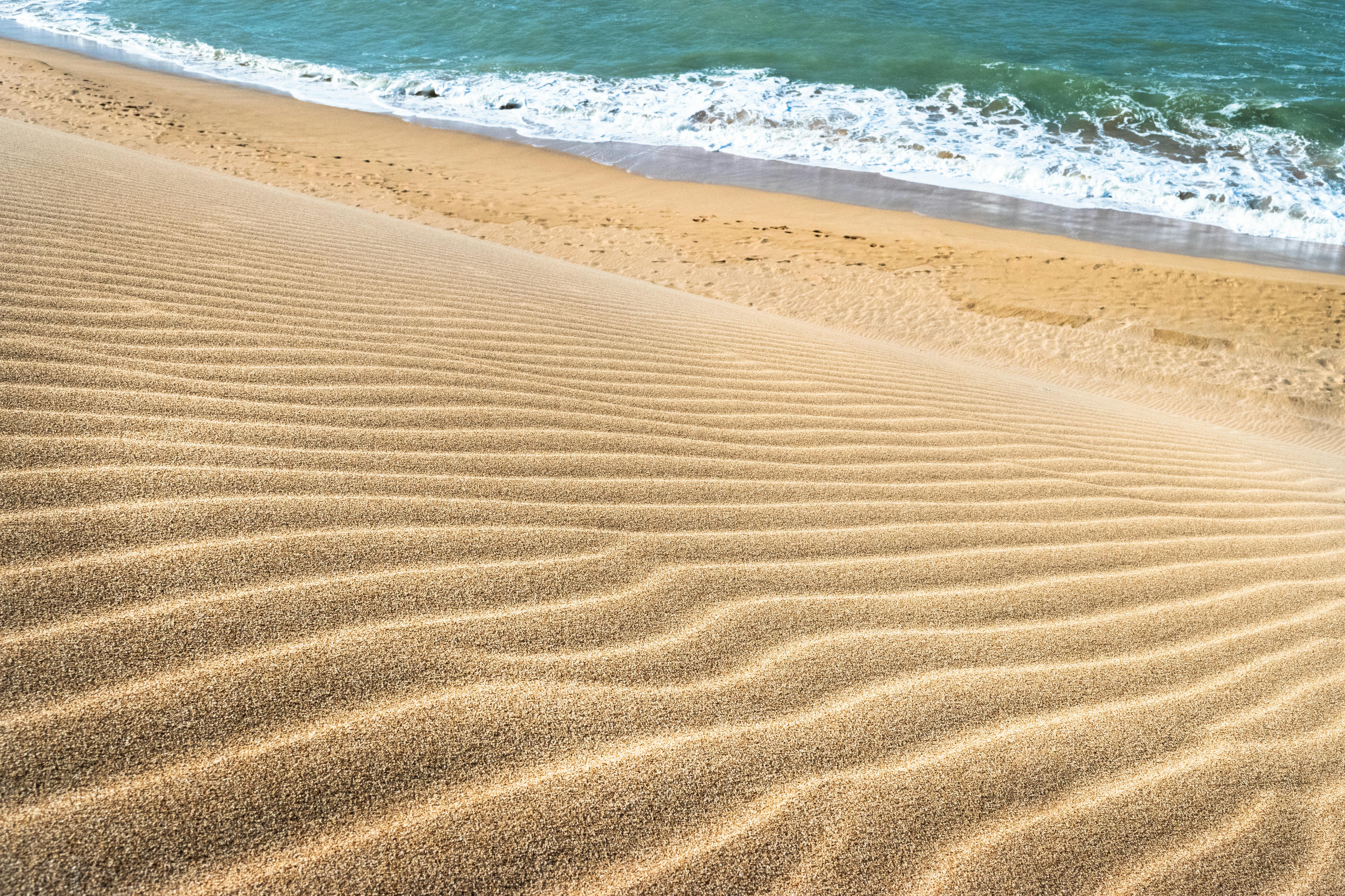 Beach Sand Ripples and a Sea · Free Stock Photo