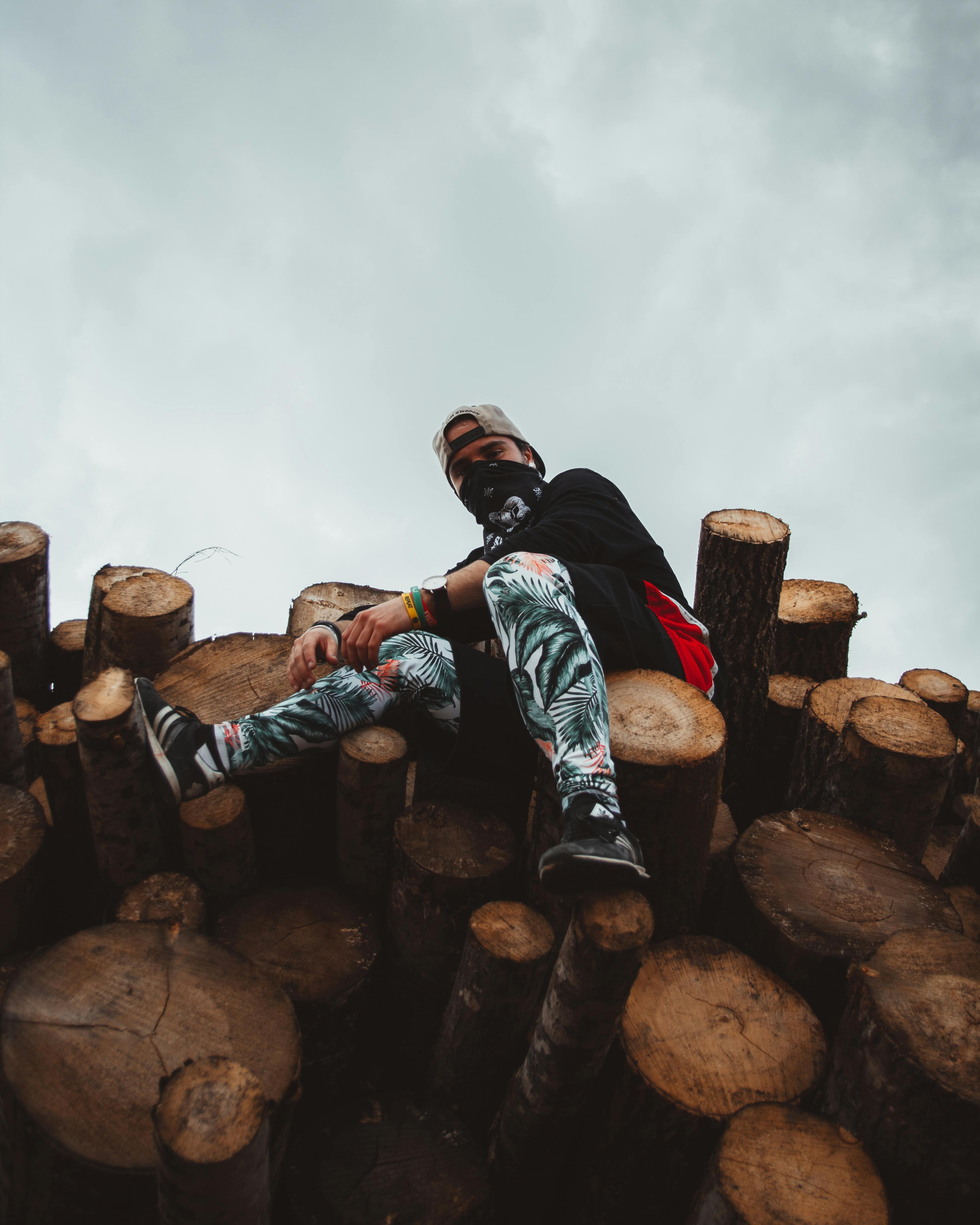 A Man Sitting on Tree Logs · Free Stock Photo