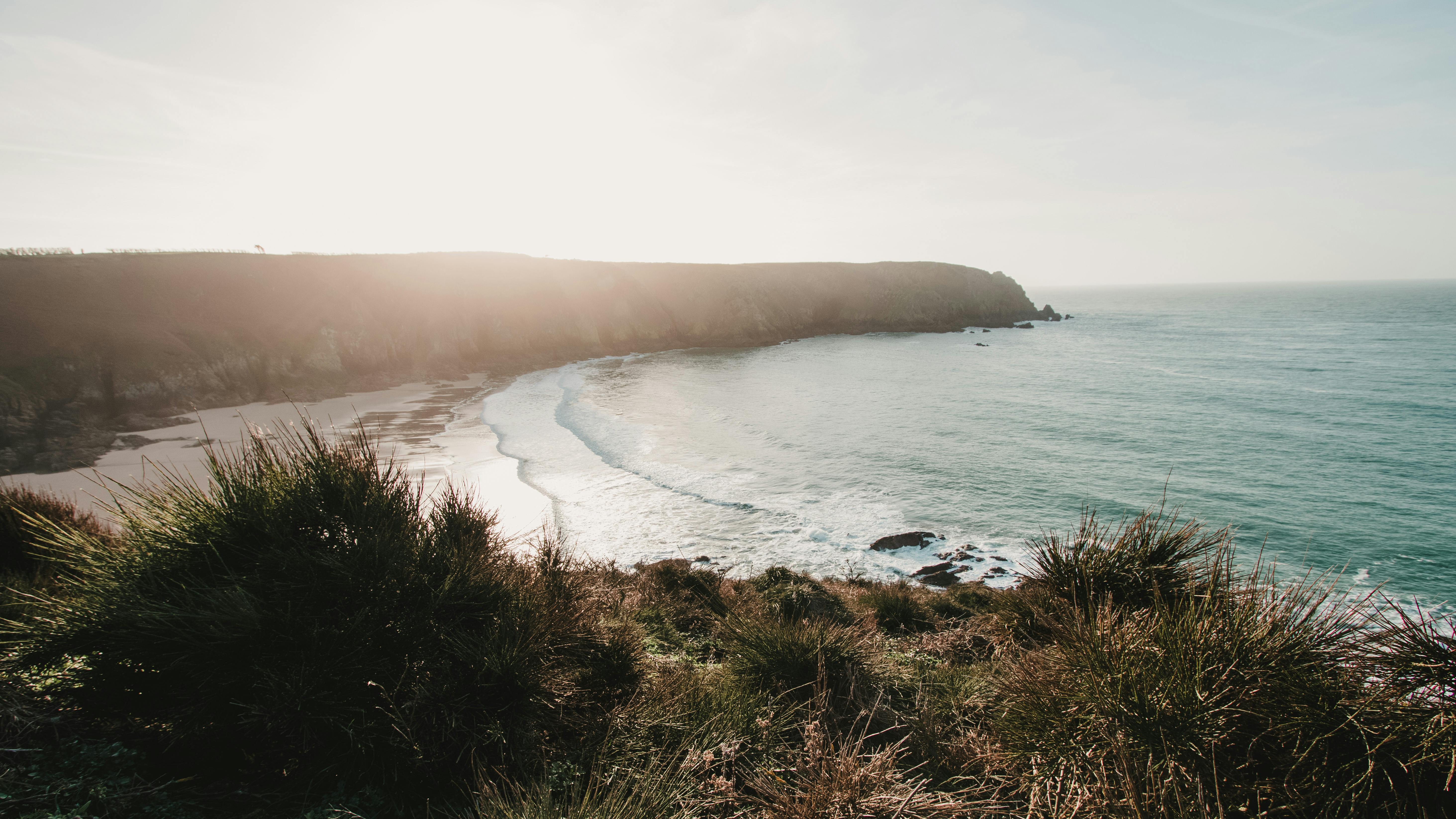 Steep coast with sandy beach of calm ocean · Free Stock Photo