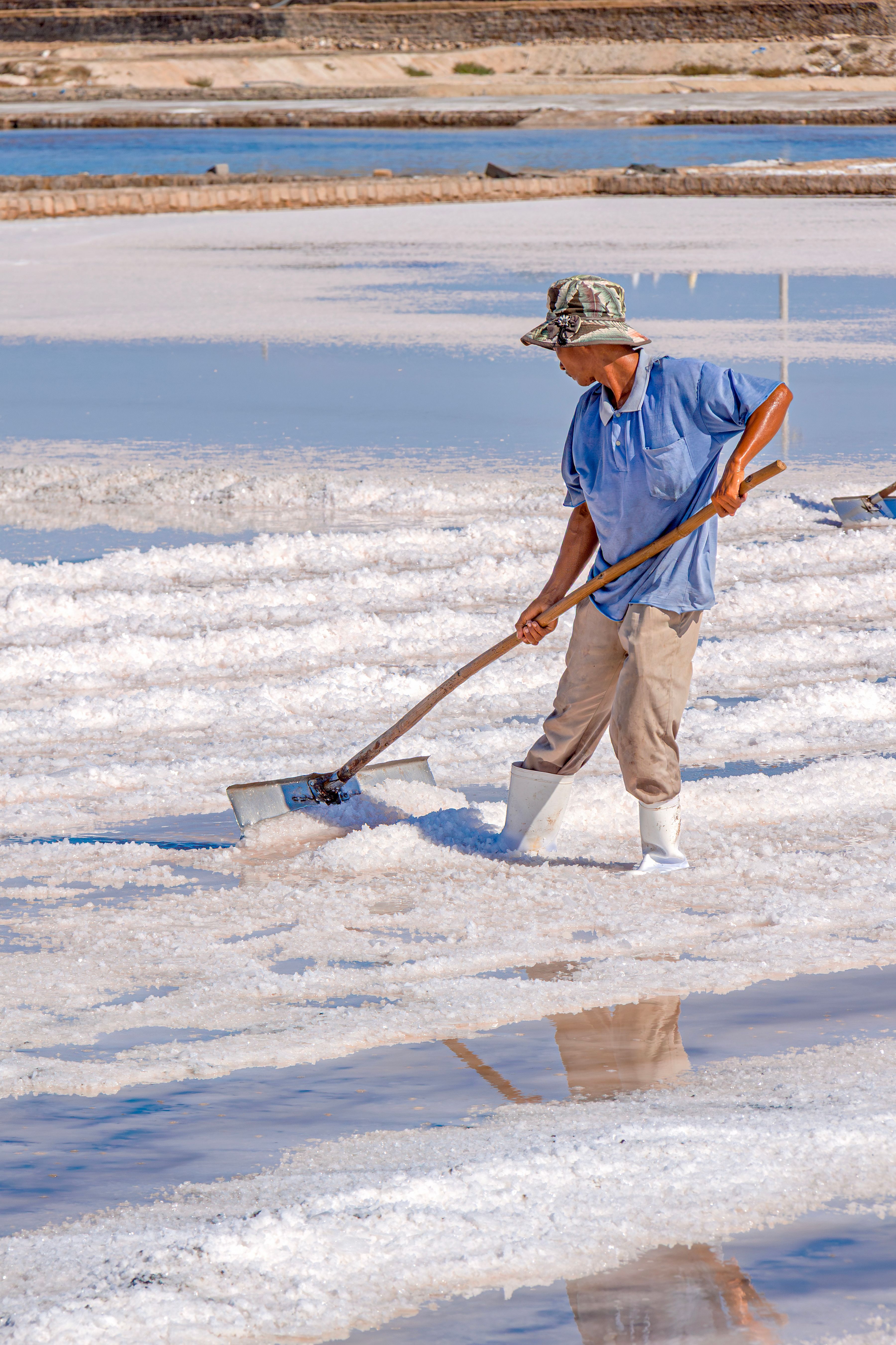 Vietnamese Salt Worker Harvesting Salt Outdoors · Free Stock Photo