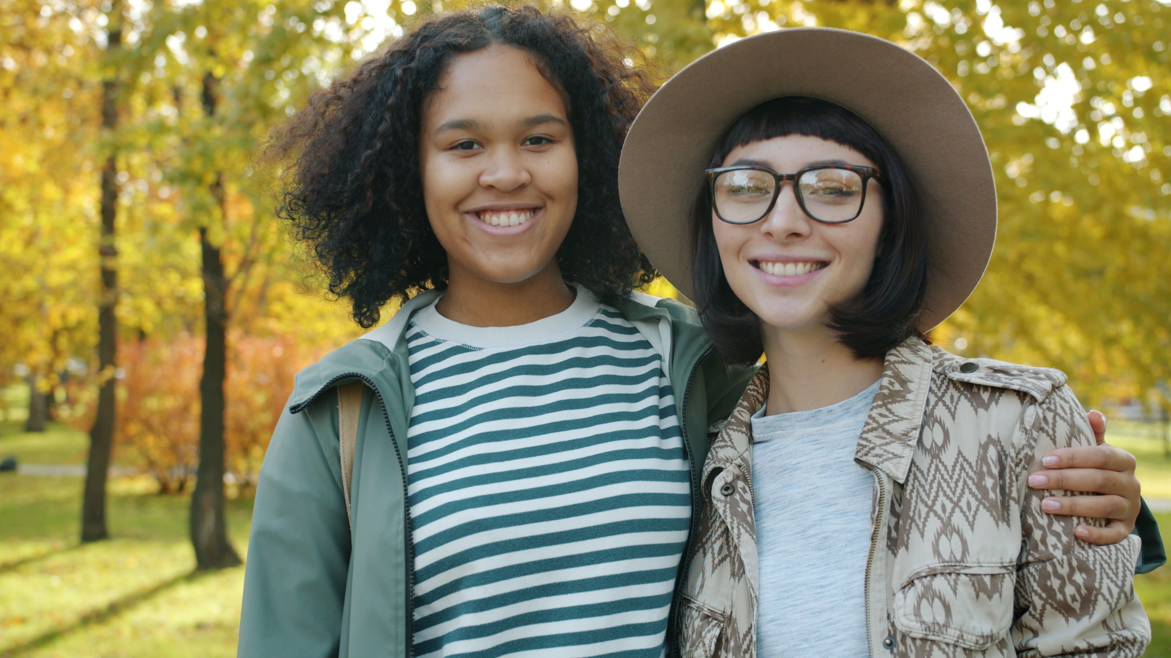 Two Women Smiling in Autumn Park Setting · Free Stock Photo