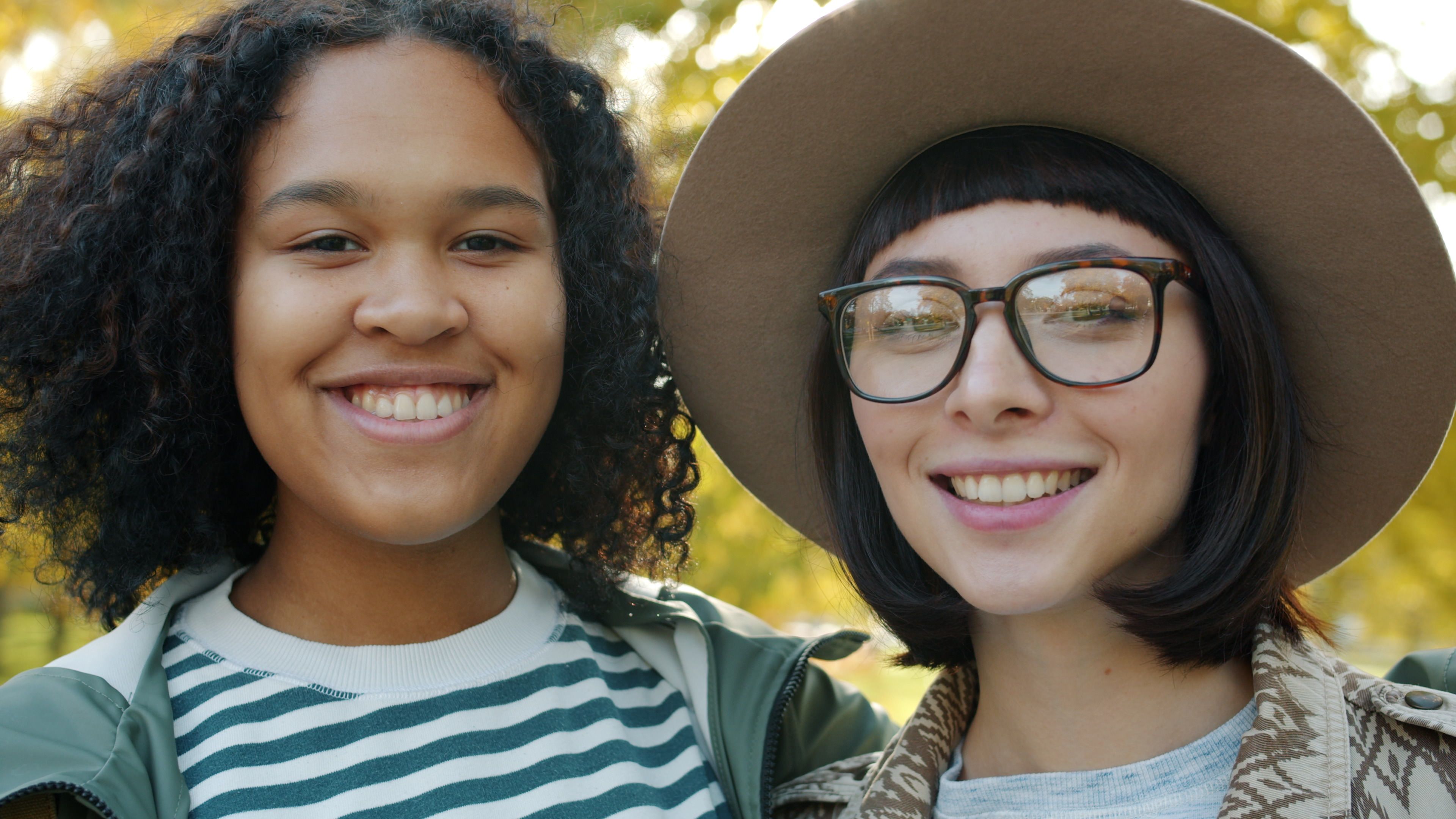 Two Women Smiling in Autumn Park Setting · Free Stock Photo