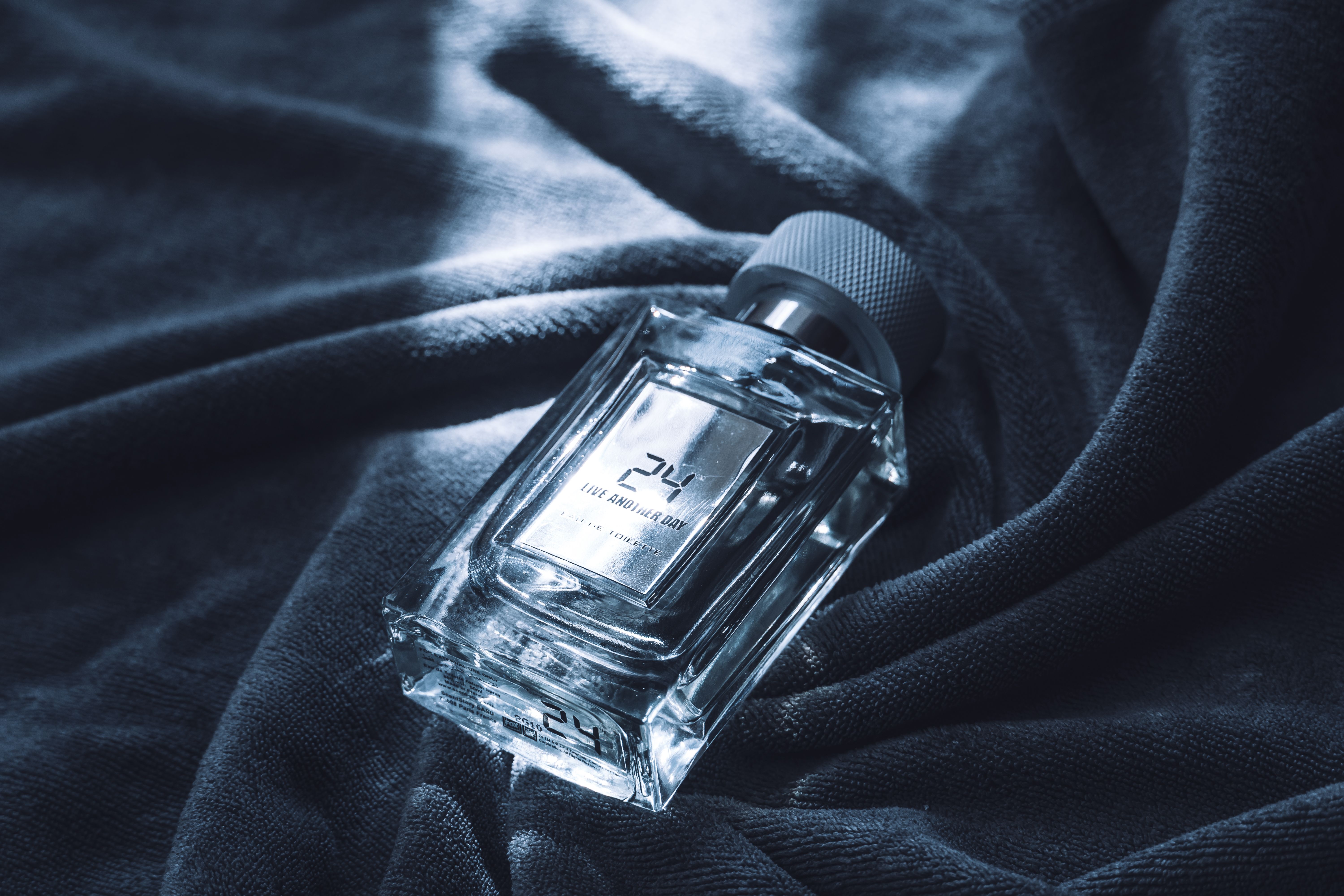 Elegant Glass Perfume Bottle on Soft Fabric · Free Stock Photo